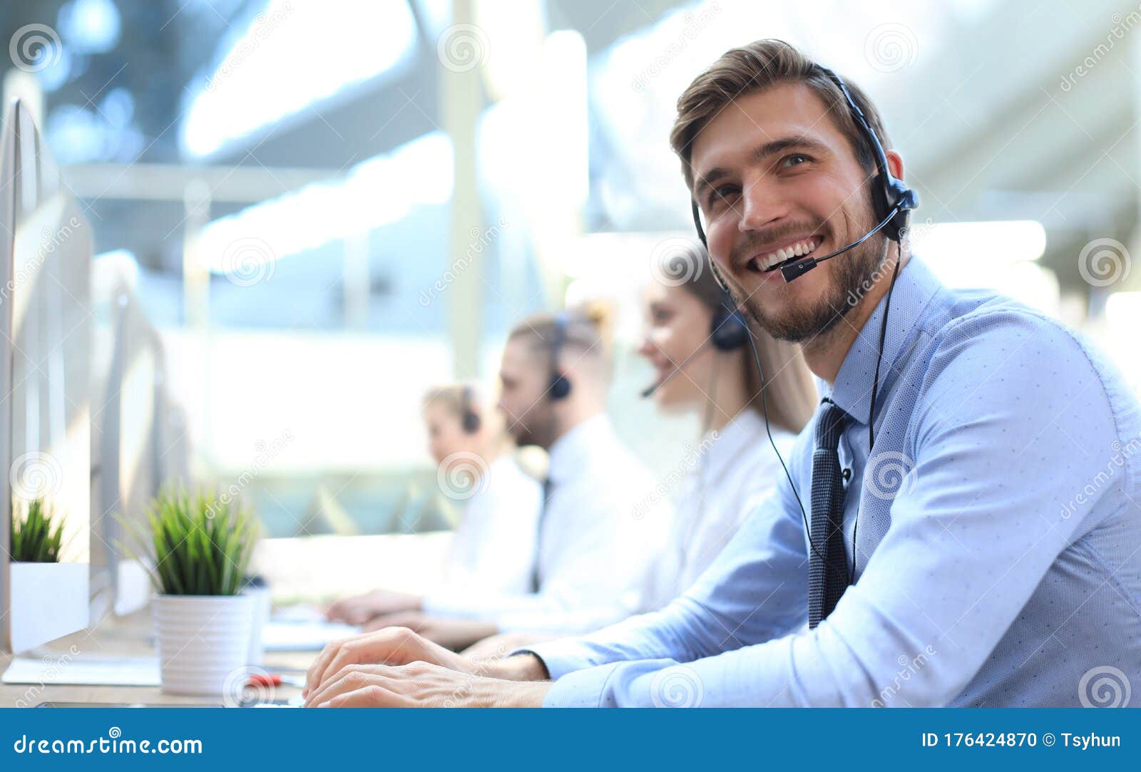 Portrait of Call Center Worker Accompanied by His Team. Smiling ...