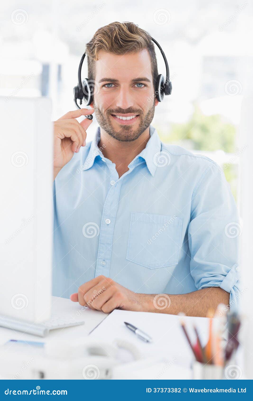 Portrait of a Casual Young Man with Headset Using Computer Stock Photo ...