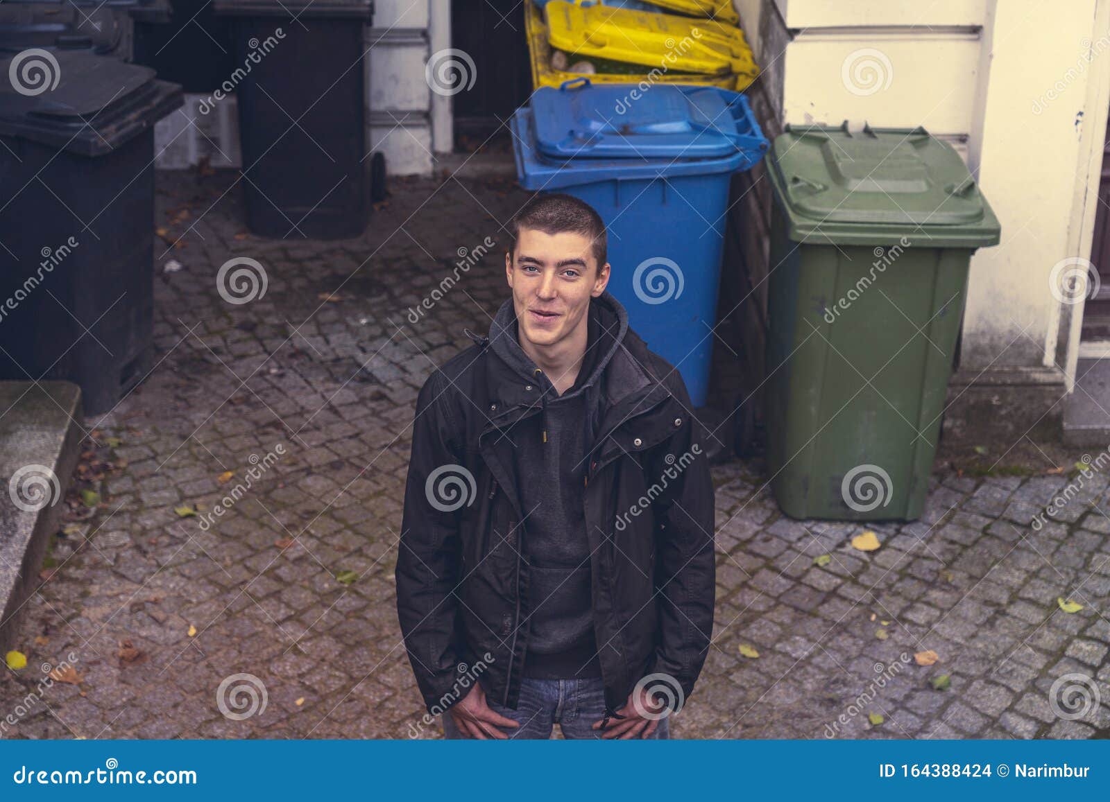 Casual Young Man Standing in Front of Garbage Cans Stock Photo - Image ...