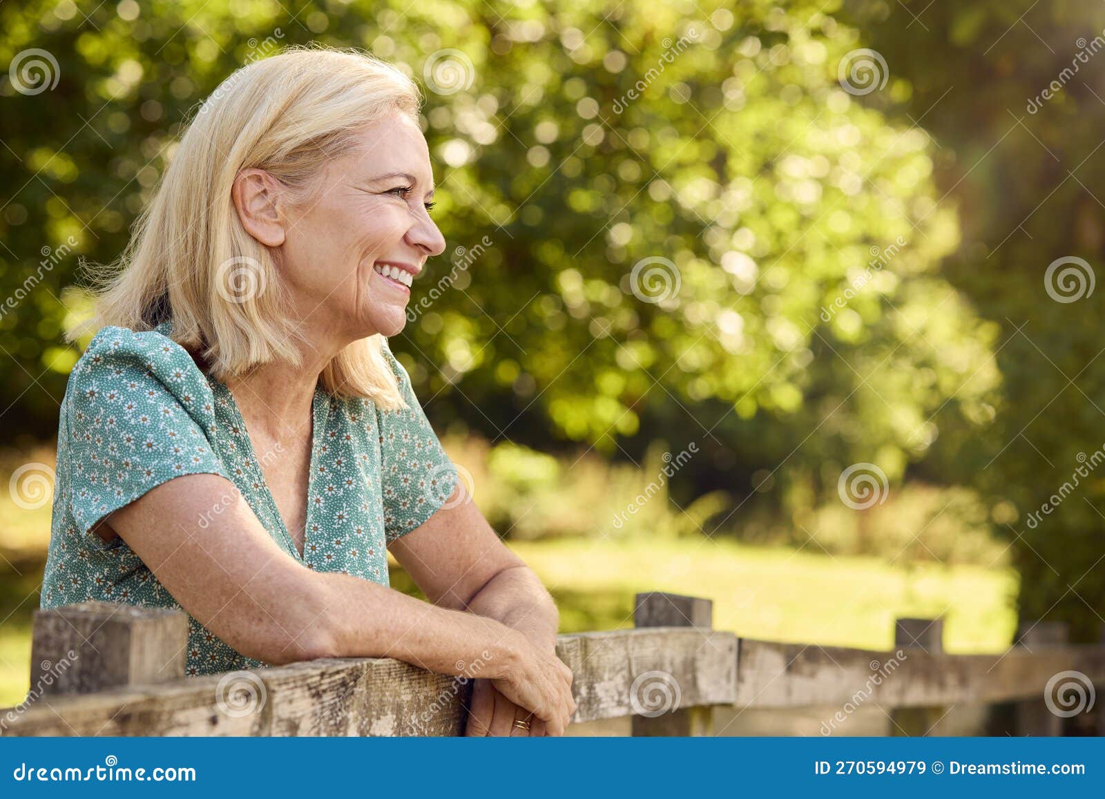 Portrait of Casually Dressed Mature or Senior Woman Leaning on Fence on ... Portrait of Casually Dressed Mature or Senior Woman Leaning on Fence on ...