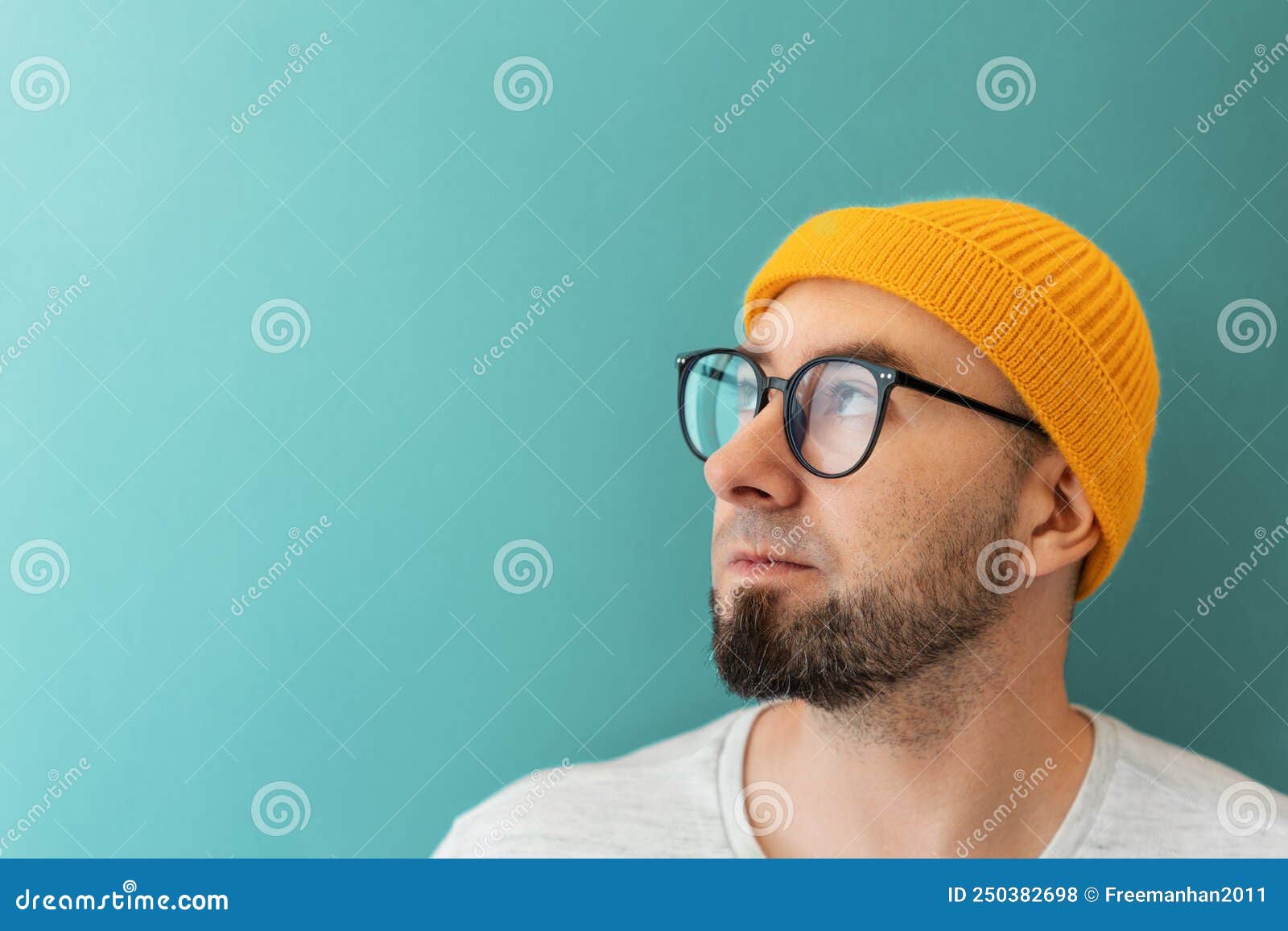 Portrait Of A Caucasian Young Bearded Man With Glasses And A Hat