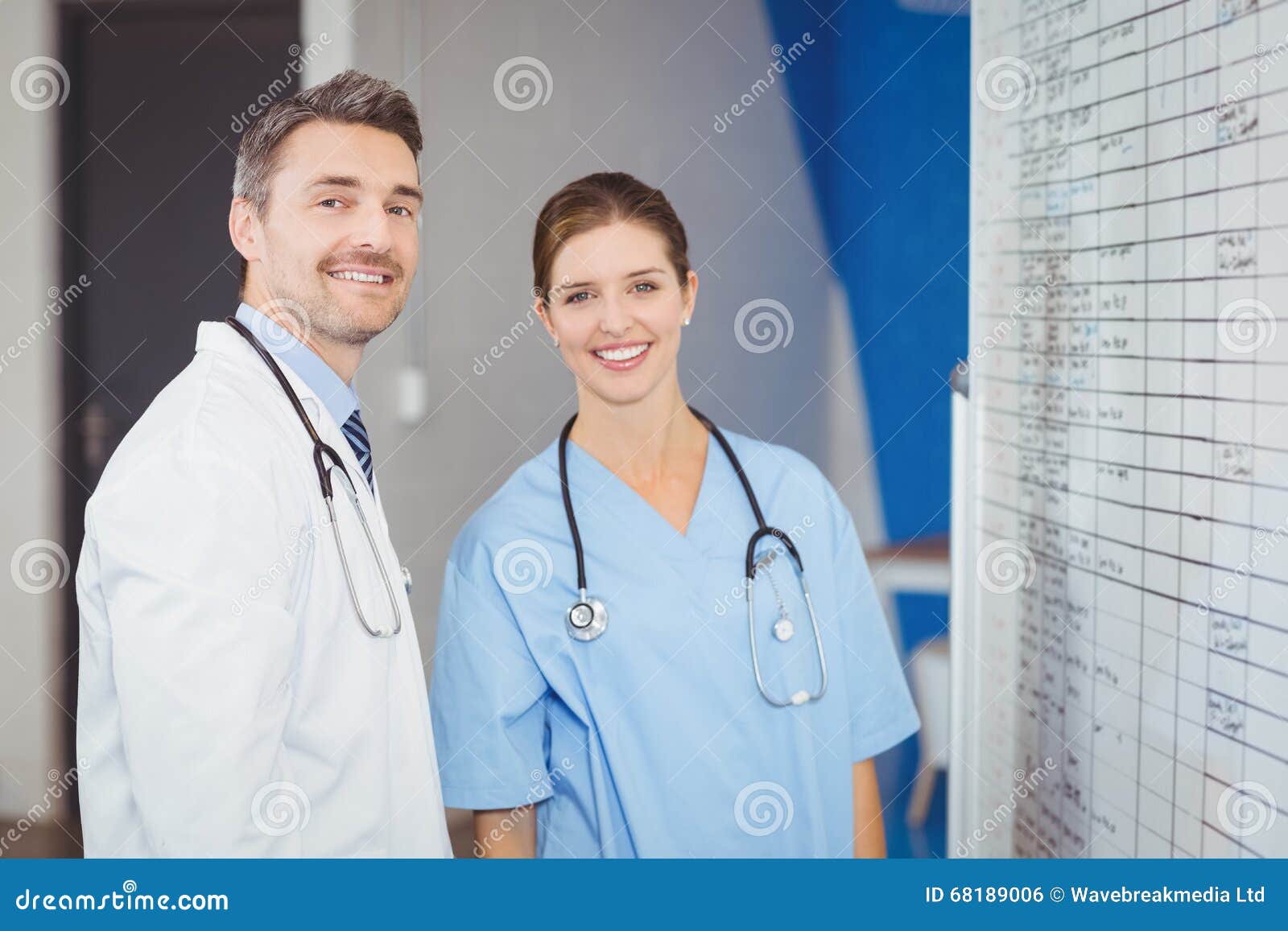 Portrait of Cheerful Doctors Standing by Chart on Wall Stock Photo ...
