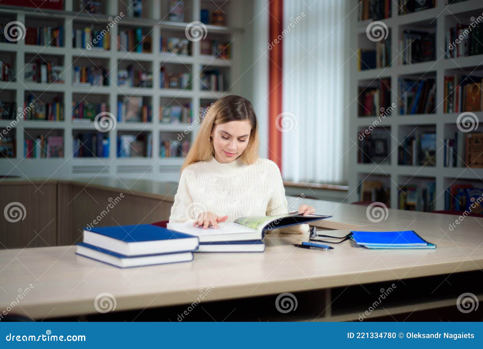 Portrait of Clever Student with Open Book Reading it in College Library ...