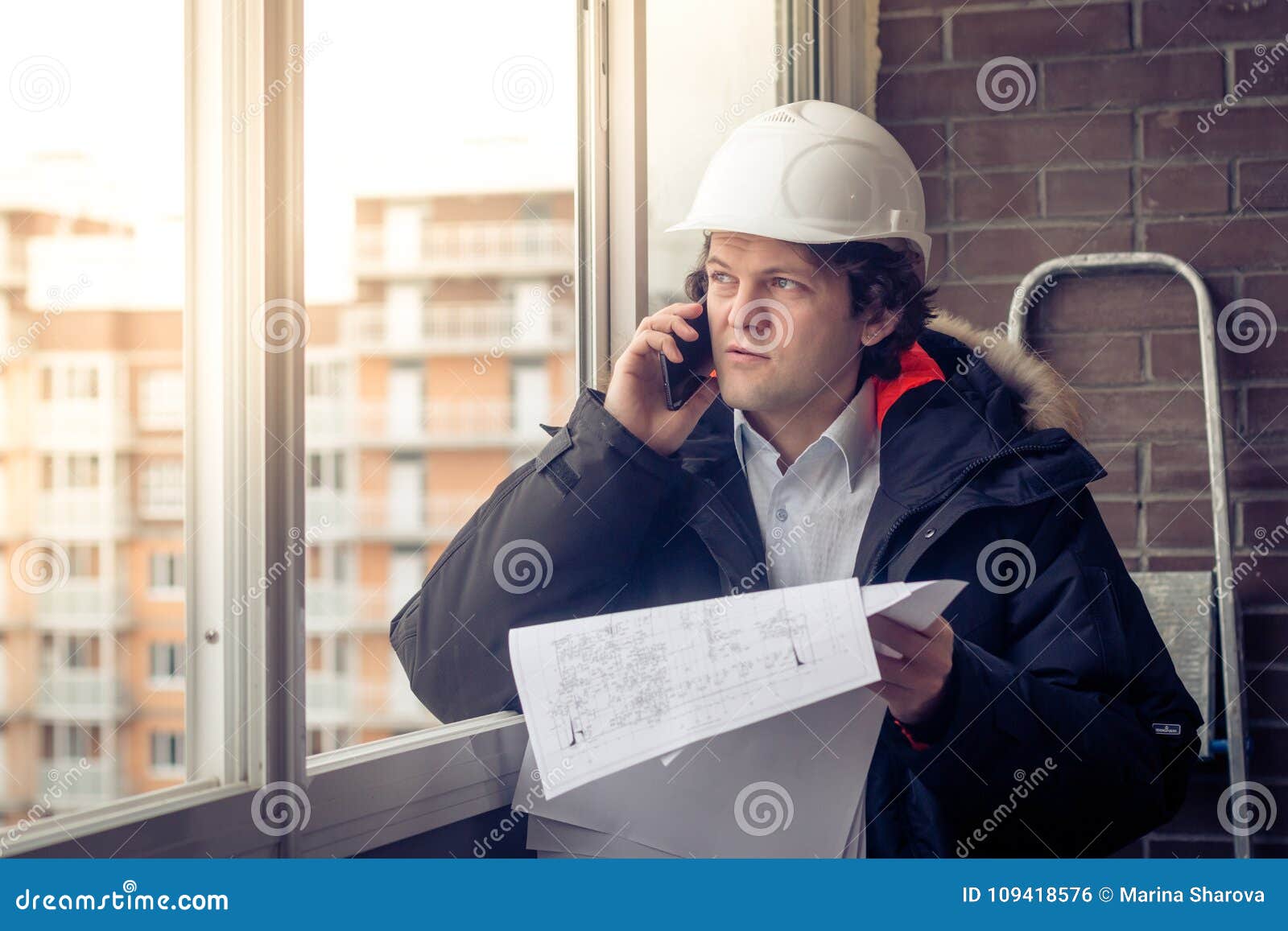 Portrait of Concerned Unshaven Builder Telling by Mobile while Keeping ...