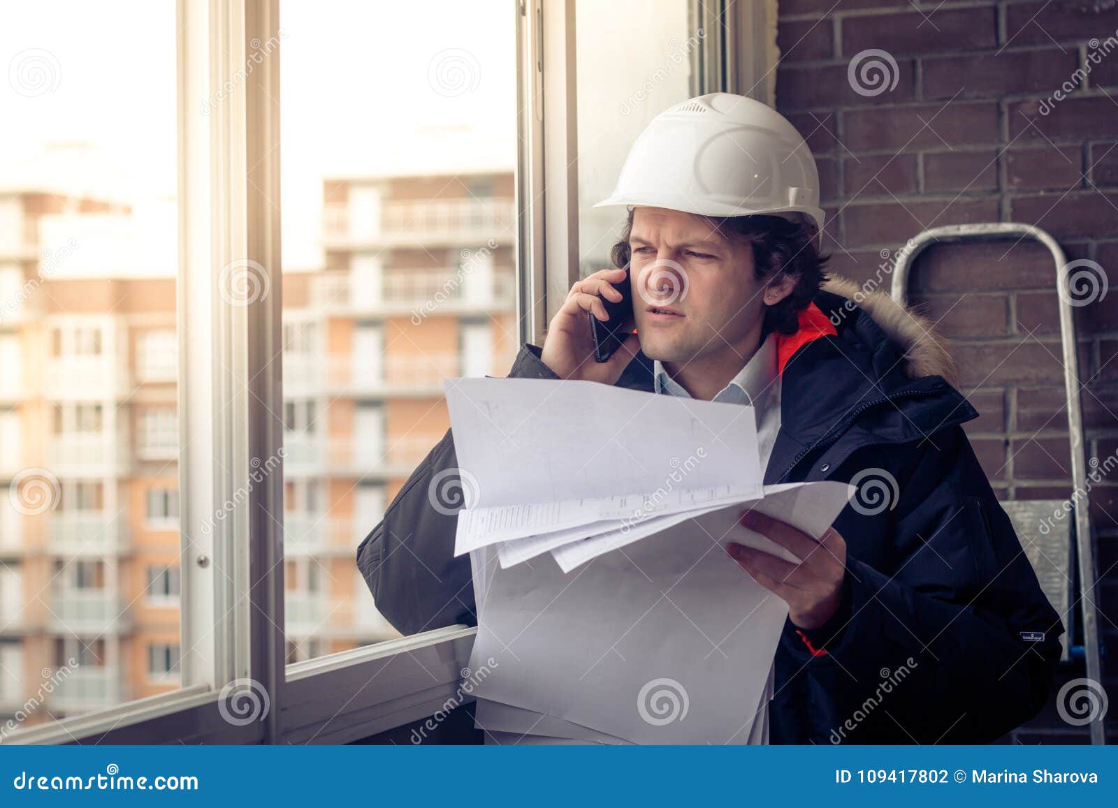 Portrait of Concerned Unshaven Builder Telling by Mobile while Keeping ...