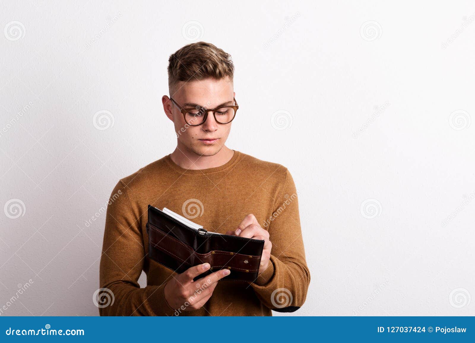 Portrait of a Confident Young Man in a Studio, Making Notes in a ...