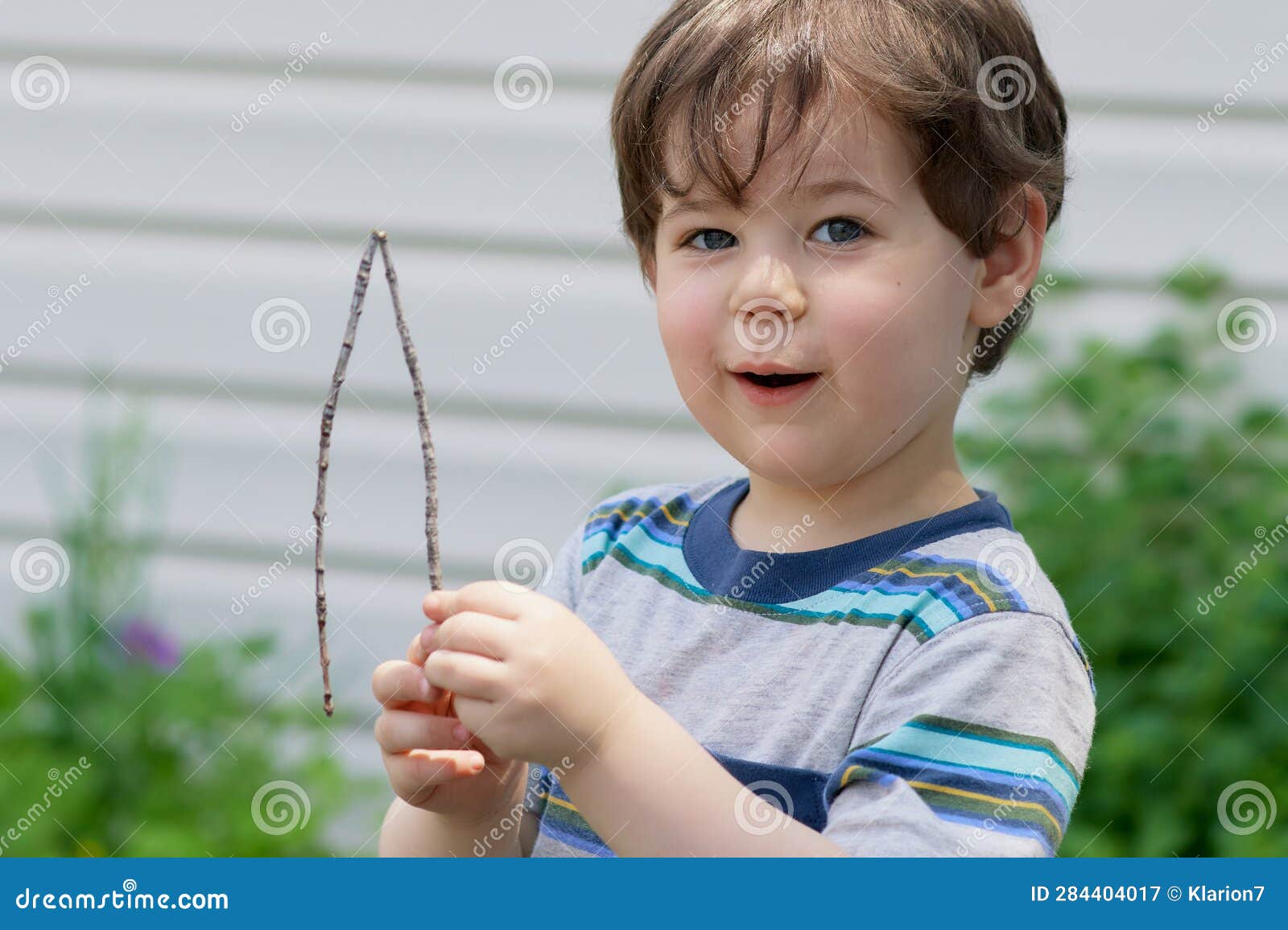 Portrait of a Cute Baby Boy Playing with a Stick in the Backyard Stock ...