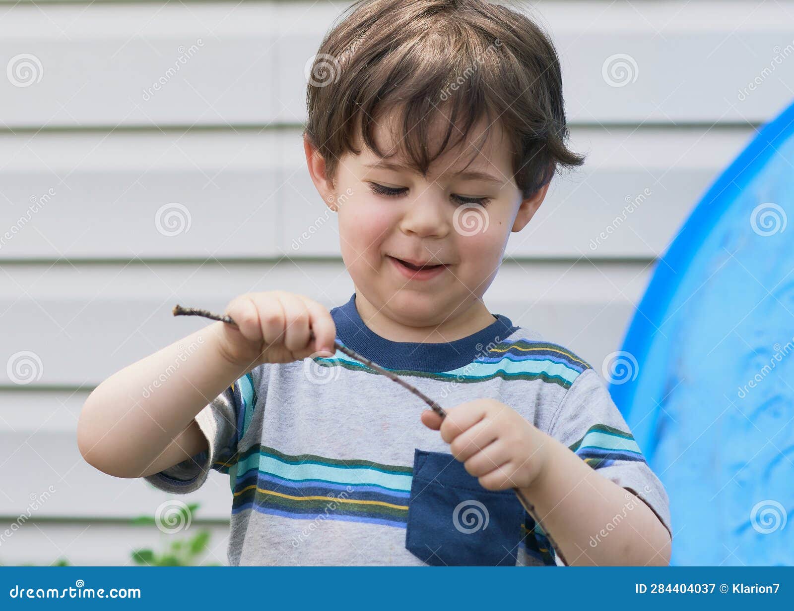 Portrait of a Cute Baby Boy Playing with a Stick in the Backyard Stock ...