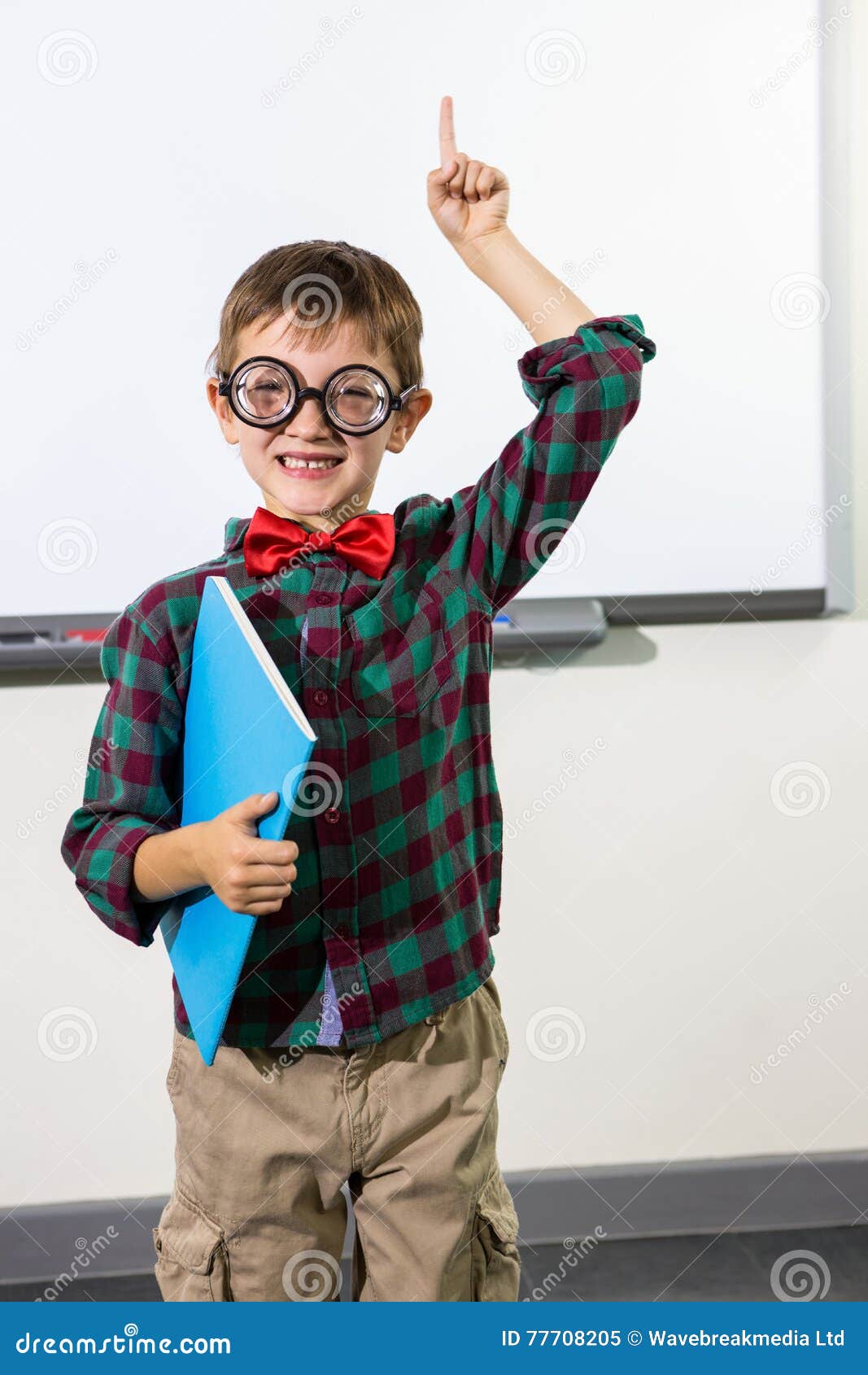 Portrait of Cute Boy with Notebook Raising Hand in Classroom Stock ...
