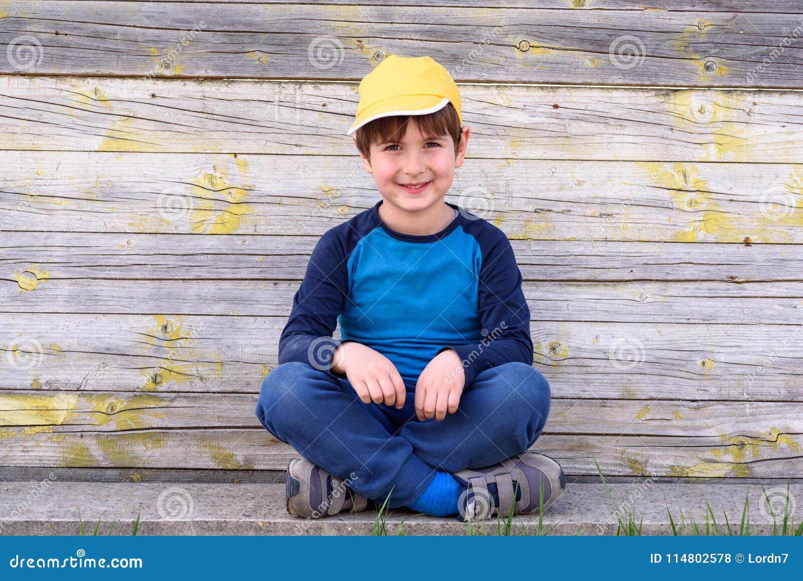 Portrait of a Cute Cheerful Boy with Yellow Cap Sitting Outdoors Stock ... Portrait of a Cute Cheerful Boy with Yellow Cap Sitting Outdoors Stock ...