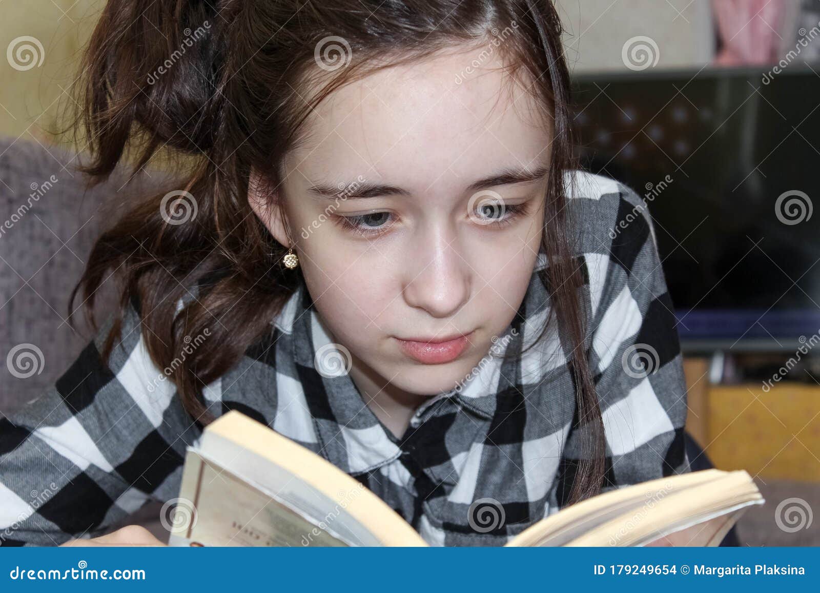 Portrait Dune Adolescente Allongée Sur Un Canapé Lisant Un Livre Photo