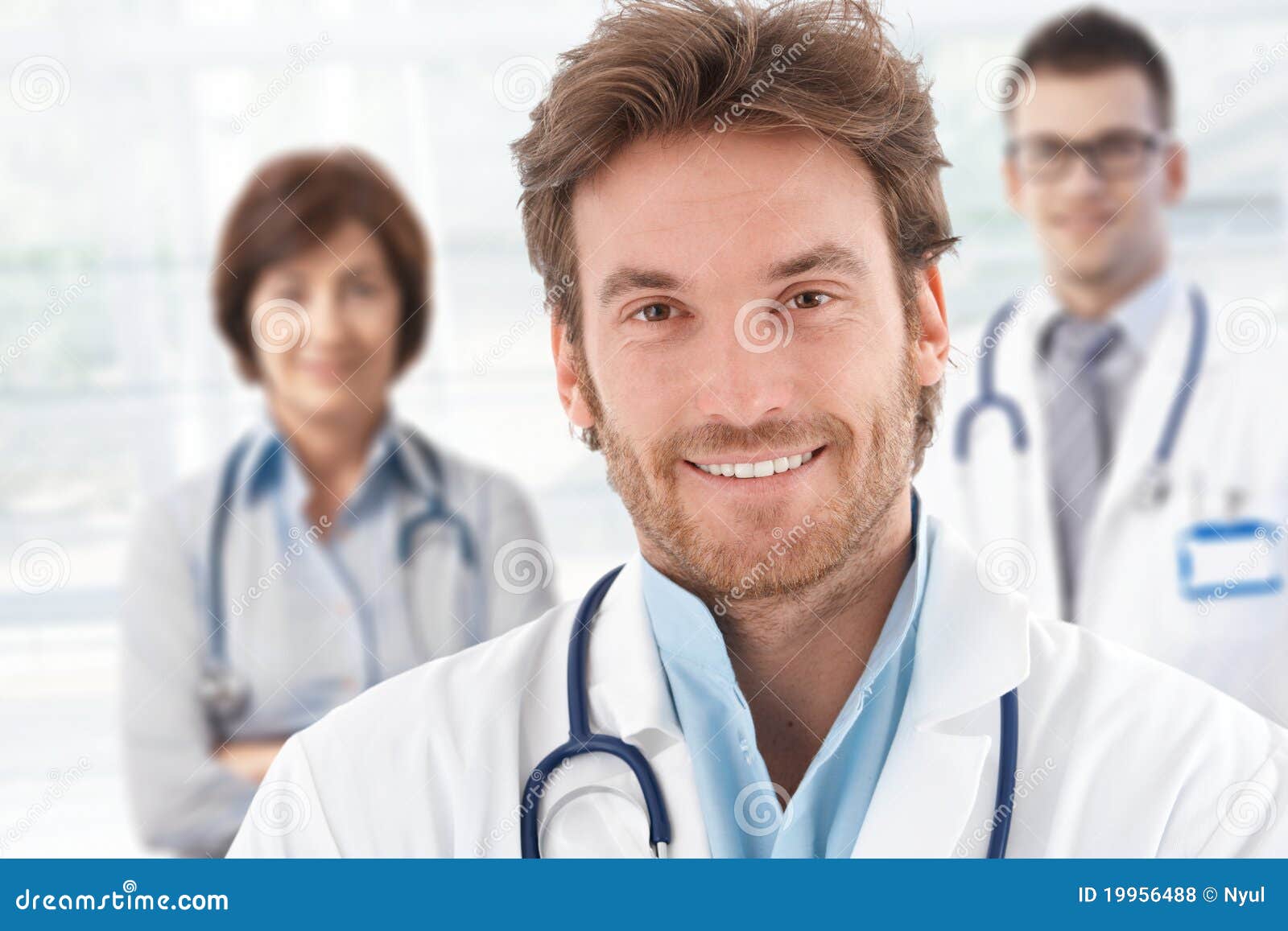 Portrait of Doctor with Colleagues Behind Stock Photo - Image of casual ...