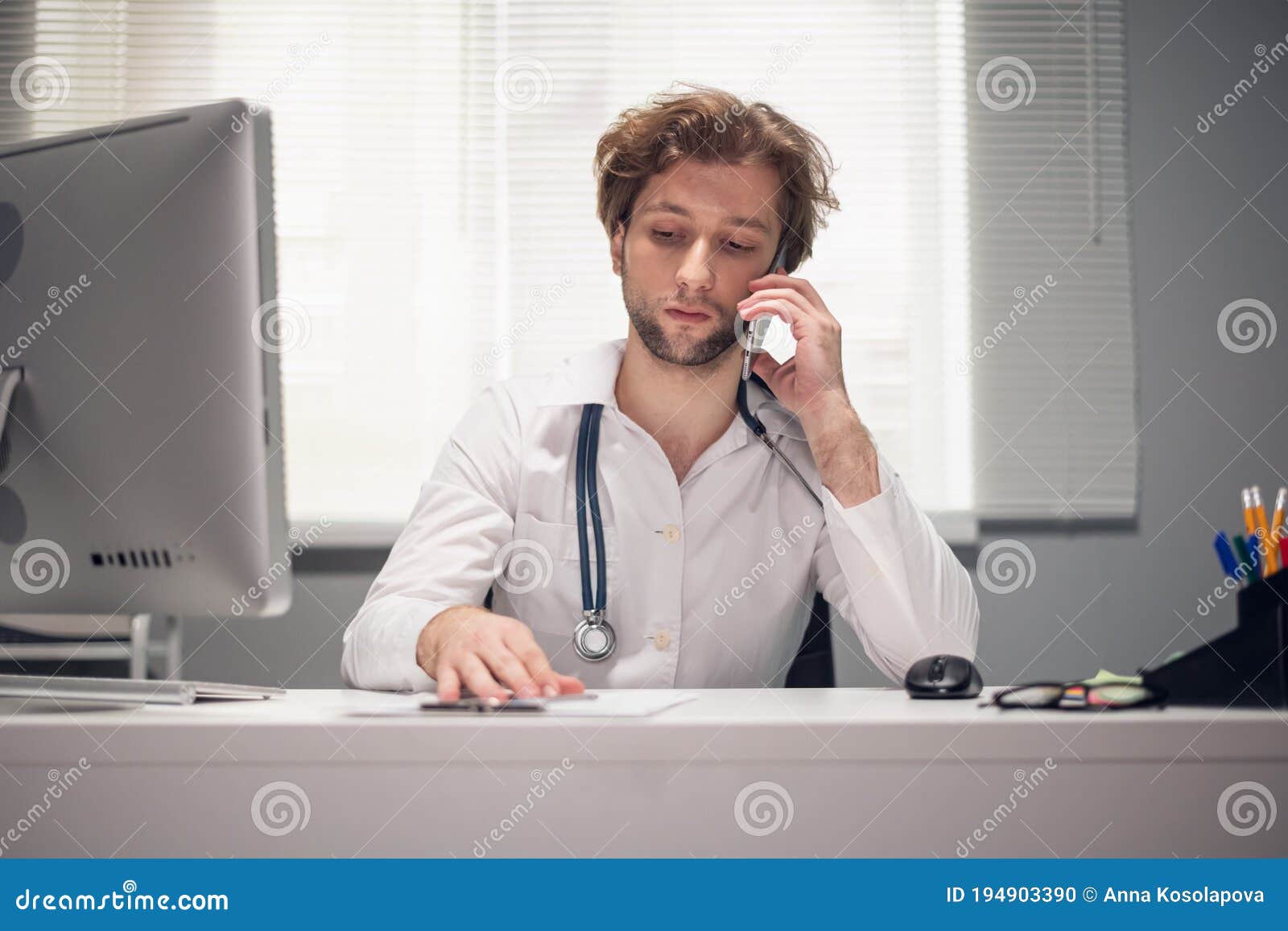 A Portrait of a Doctor Talking Over the Phone in His Office, Making ...