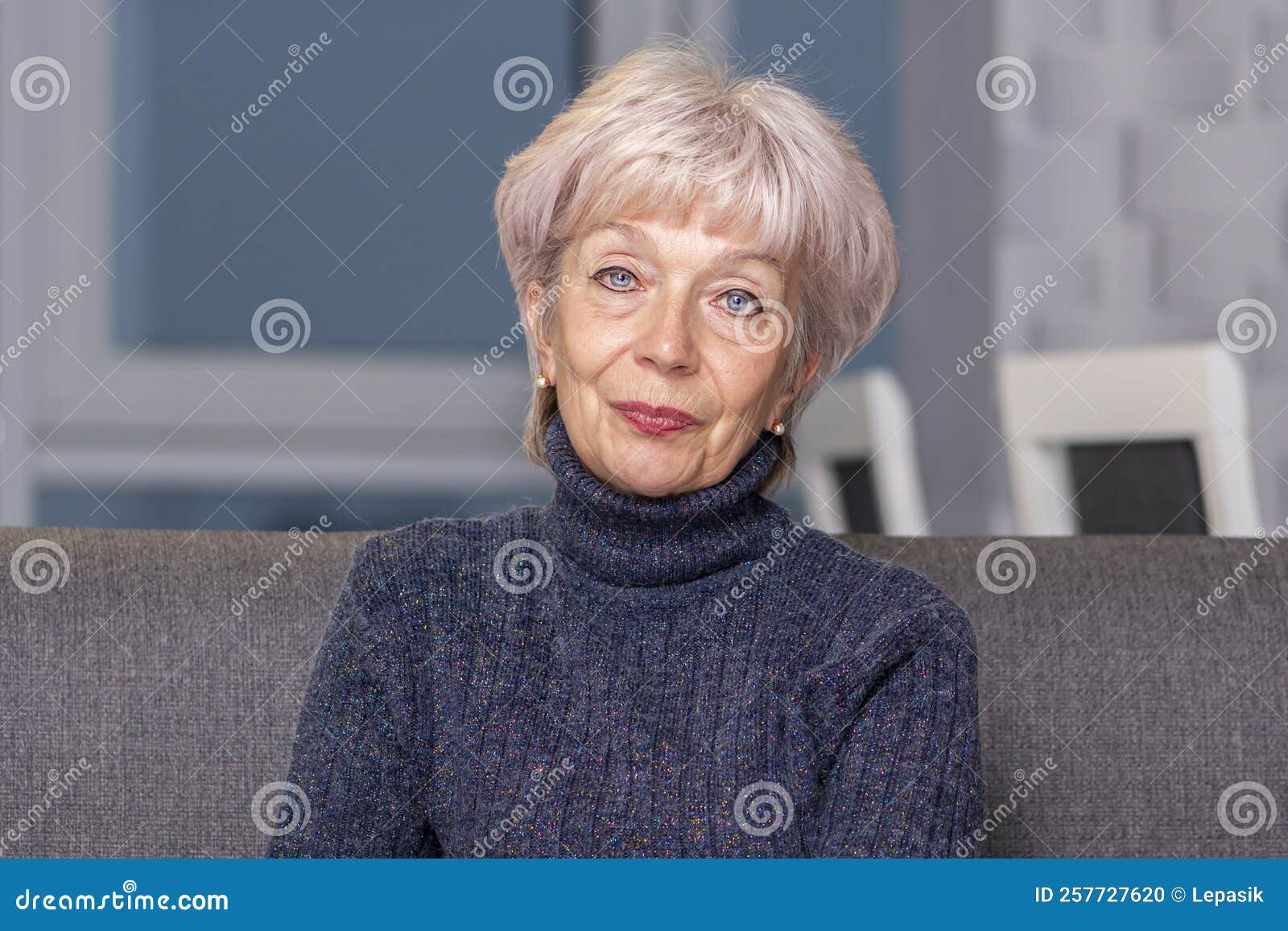 Portrait Of An Elderly Blonde Woman 60 65 Years Old Sitting On A Couch