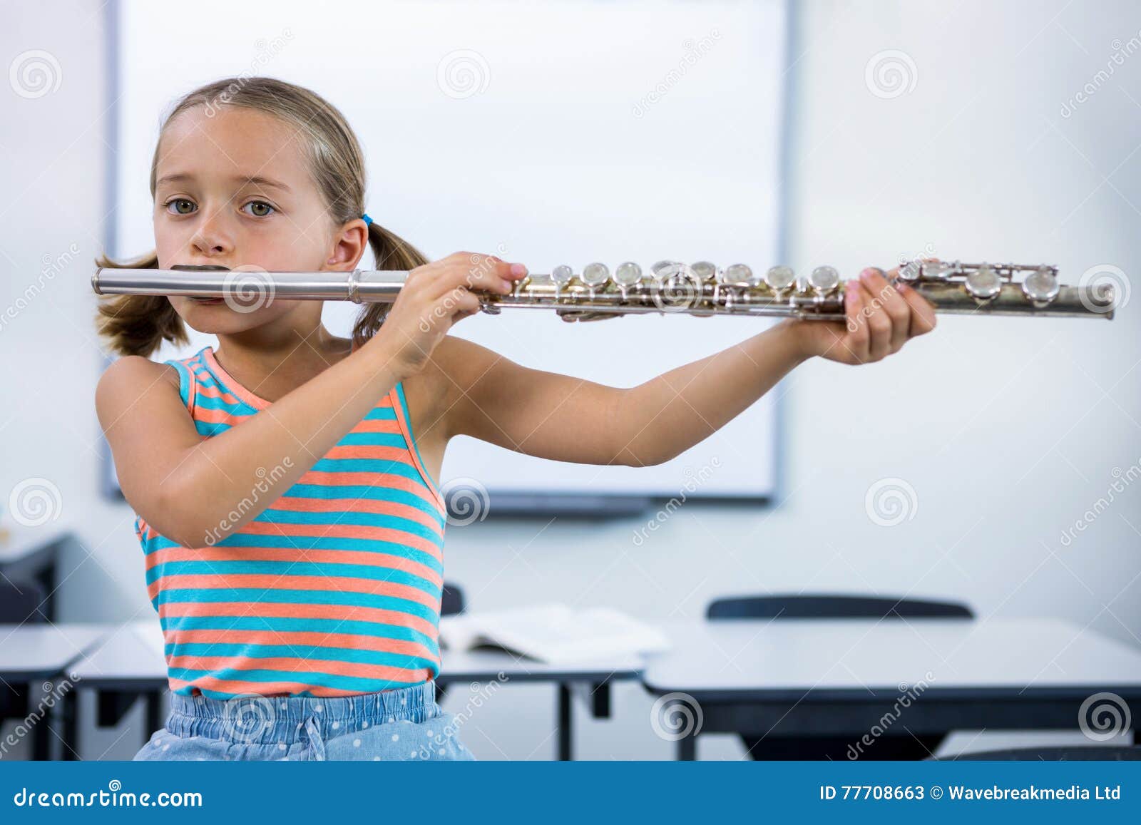 Portrait of Elementary Girl Playing Flute in Classroom Stock Image ...