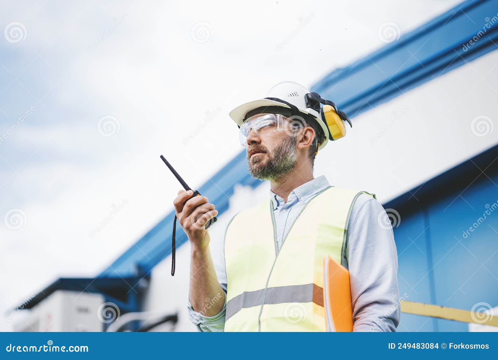 Portrait of Engineer Using Walkie-talkie Talking in Production Site ...