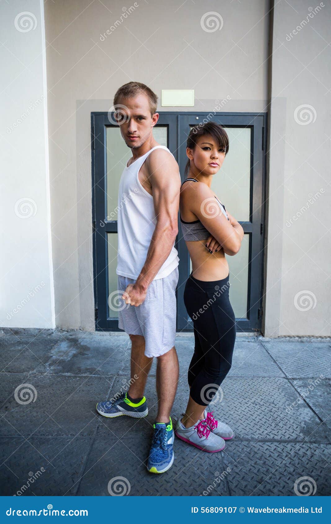 Portrait of Extreme Athletes Standing Back To Back and Looking at ...