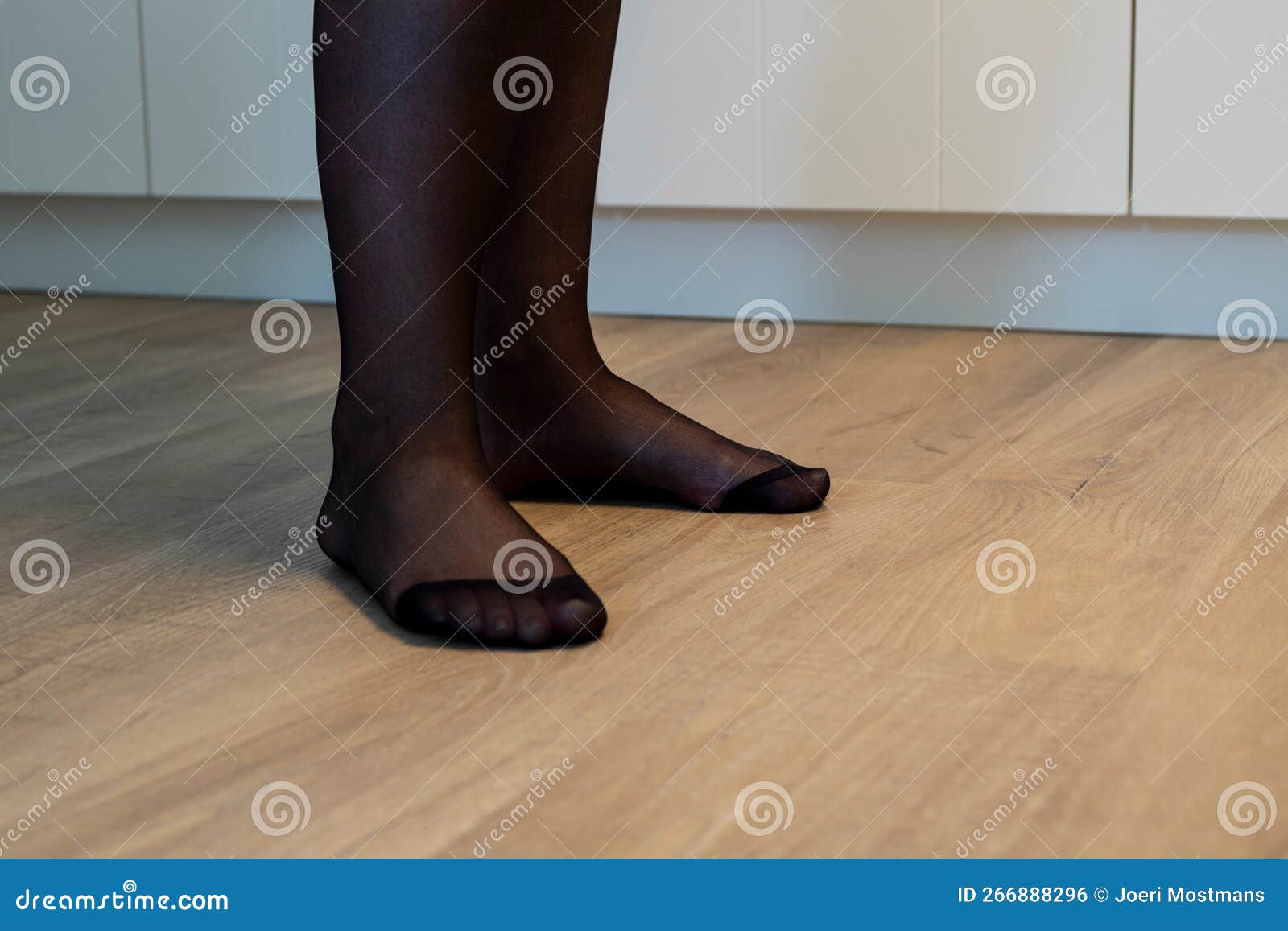 A Portrait Of The Feet Of A Girl In Black Nylon Pantyhose With