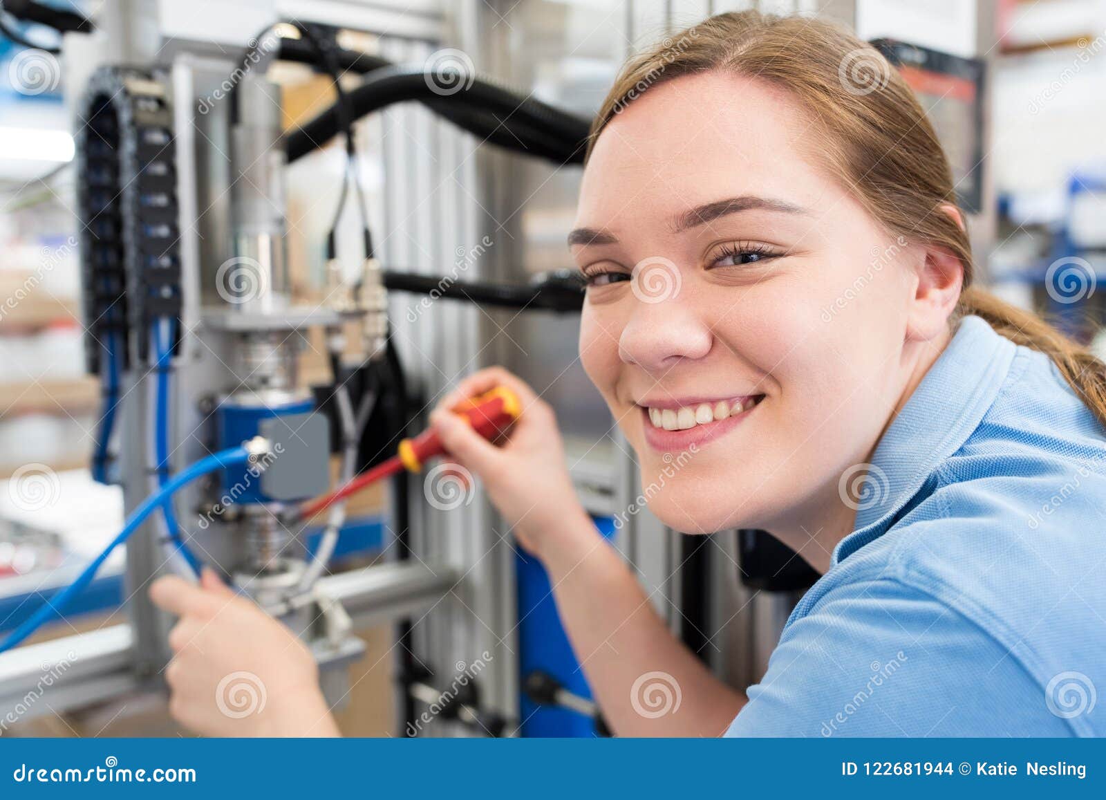 Portrait of Female Apprentice Engineer Working on Machine in Factory ...