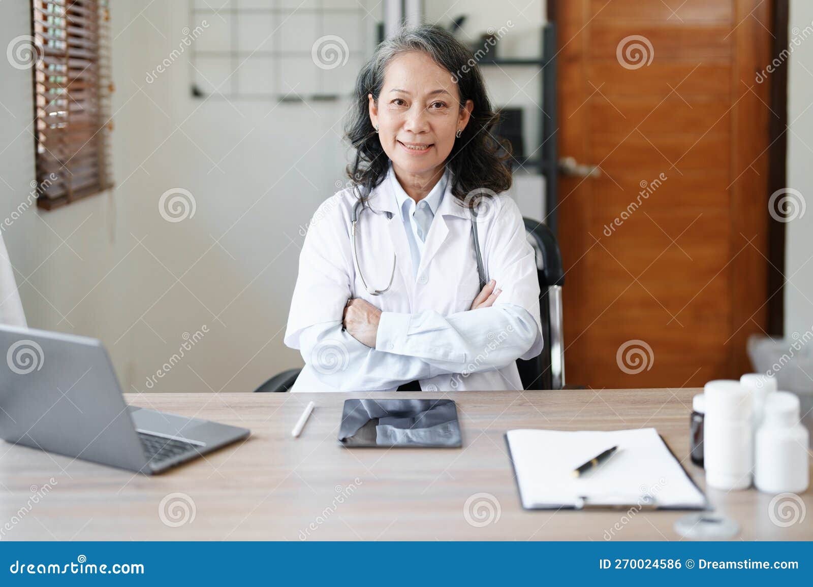 Portrait of a Female Doctor Using a Computer and a Document Analyzing a ...