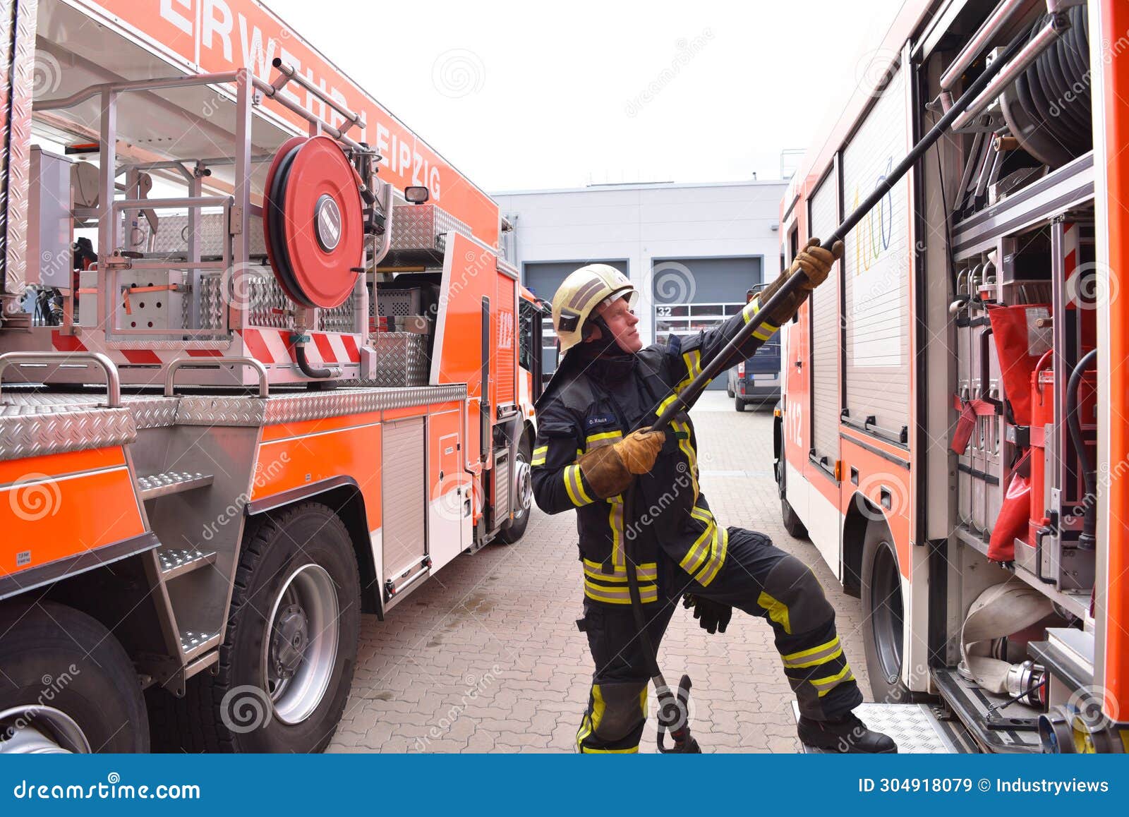 Portrait of a Firefighter at the Emergency Vehicle in the Fire Station ...