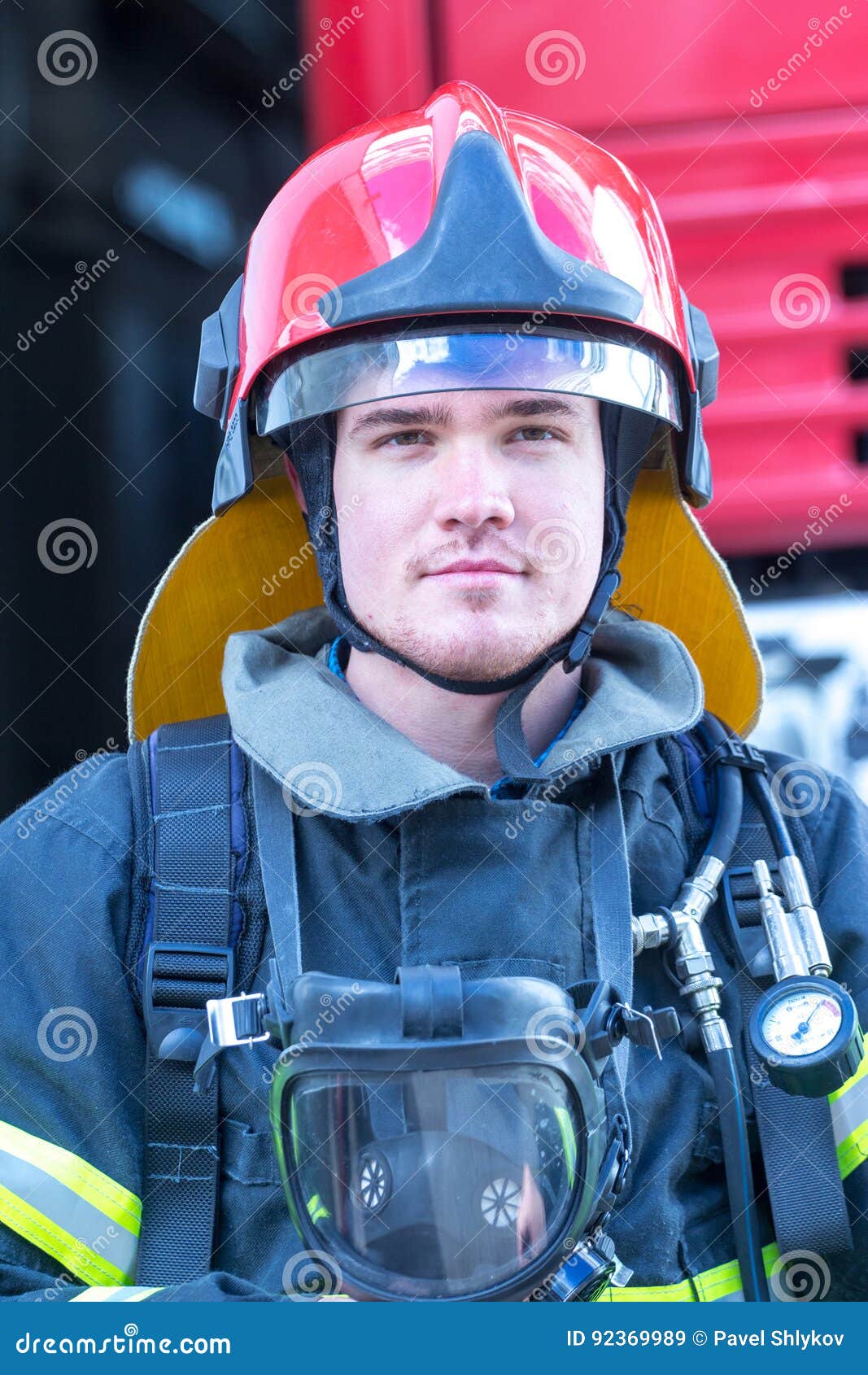 Portrait Of A Fireman In Uniform Holding A Helmet And Oxygen Mask ...