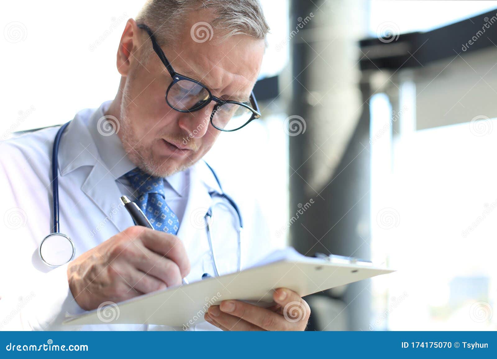 Portrait of Focused Senior Doctor Writing Reports Stock Photo - Image ...