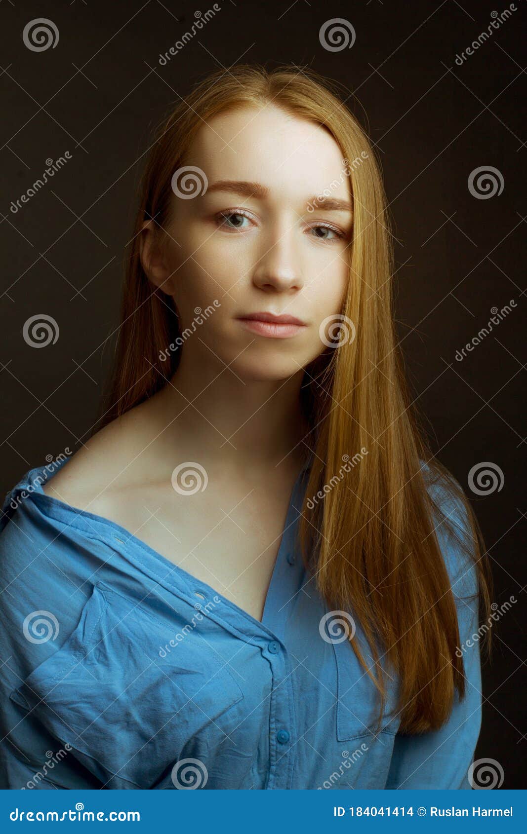 Portrait Of Girl Young Woman With Long Blonde Hair Wearing A Blue Shirt
