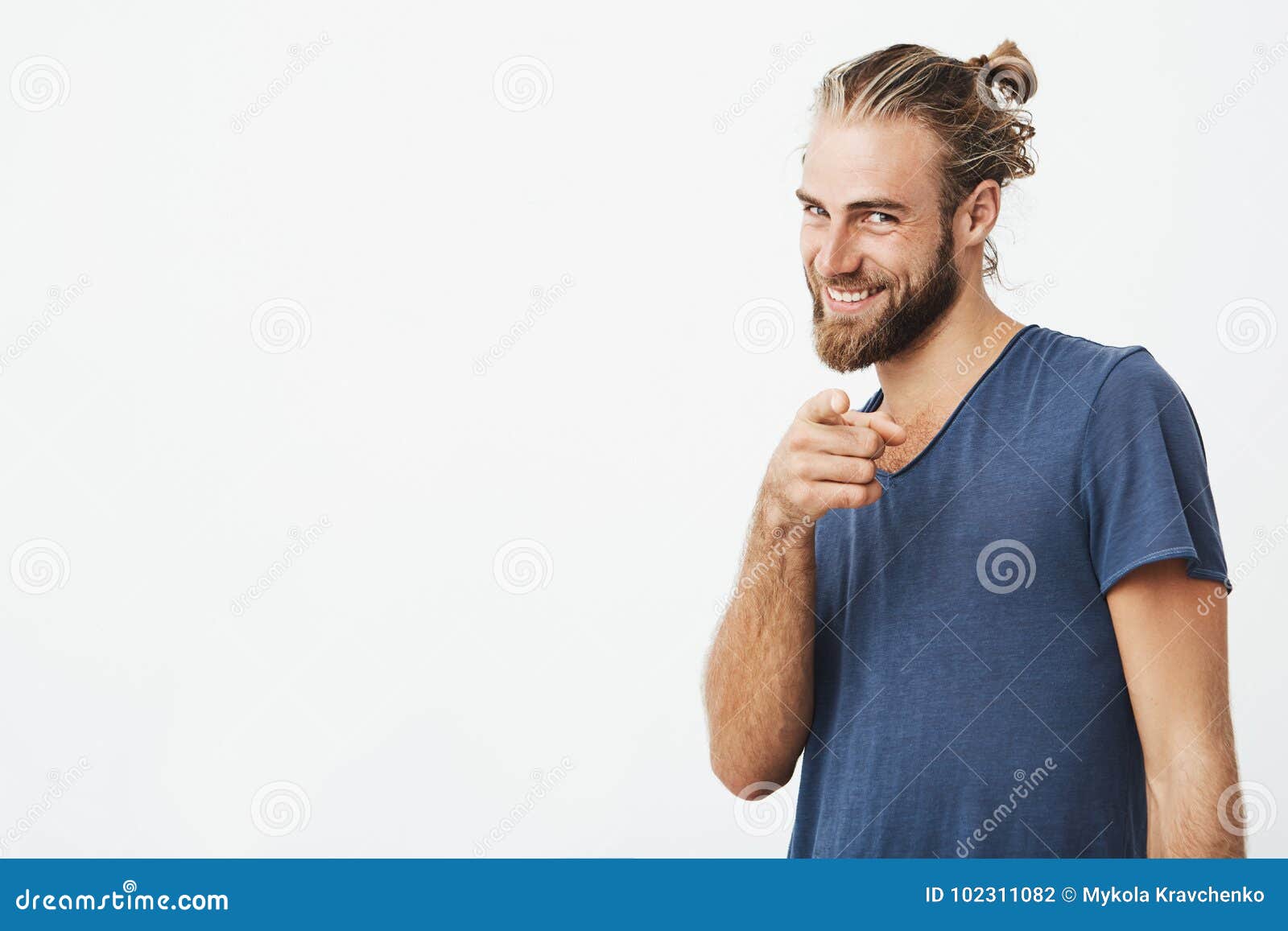 Portrait Of Good Looking Bearded Man With Great Hairdo Pointing With