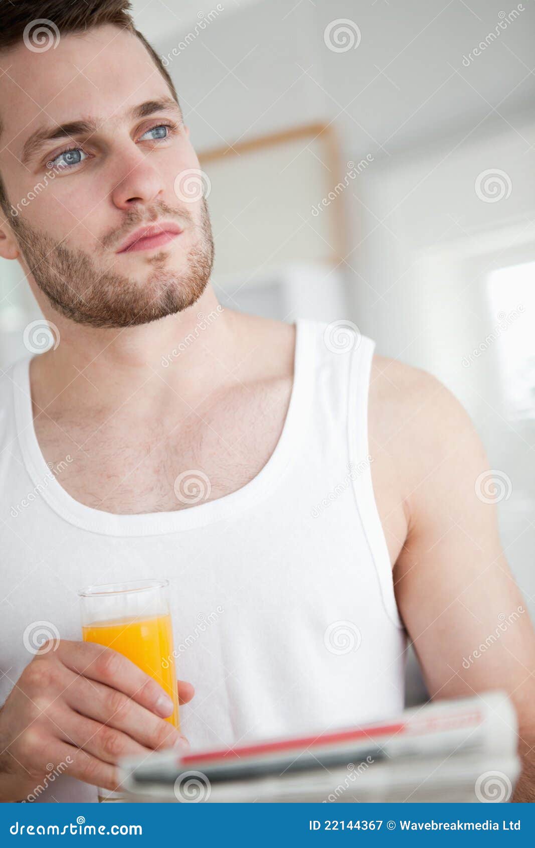 Portrait of a Good Looking Man Drinking Orange Juice while Reading the ...