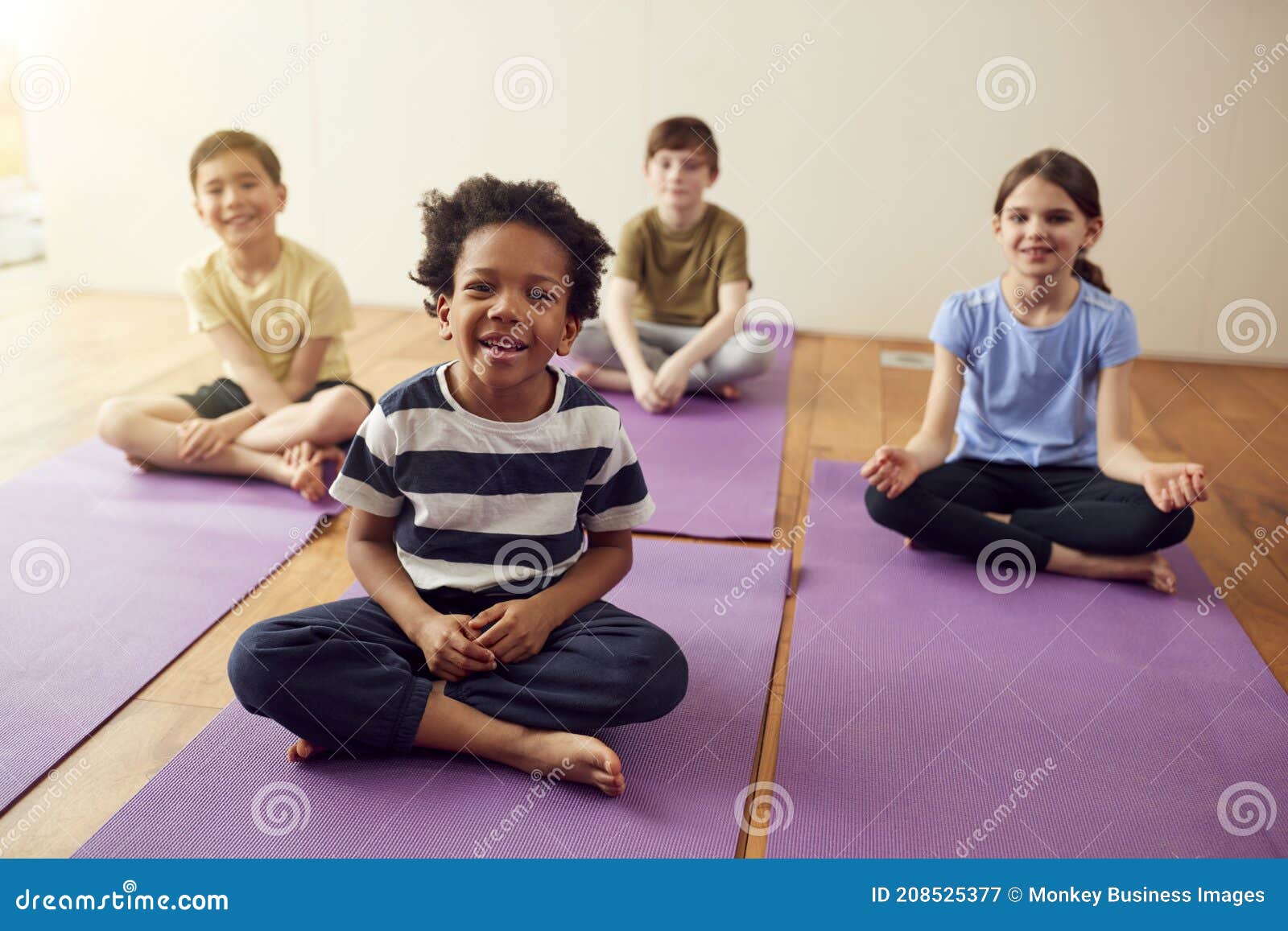 Portrait of Group of Children Sitting on Exercise Mats in Exercise ...