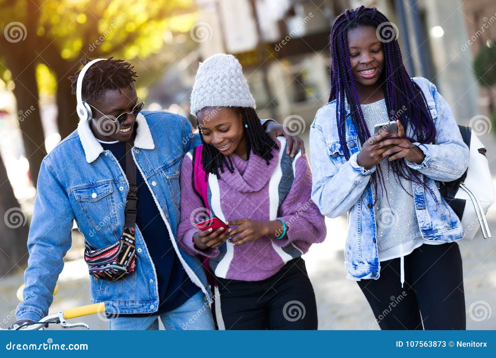 Group of Three Friends Using Mobile Phone in the Street. Stock Image ...