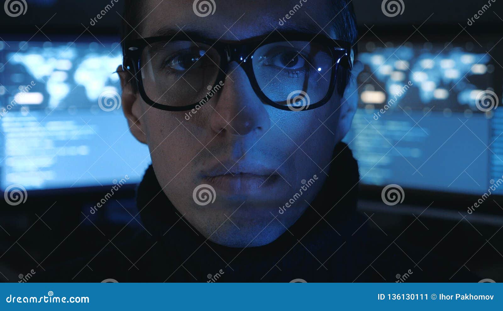 Portrait of Hacker Programmer in Glasses Looks at Camera while Blue ...