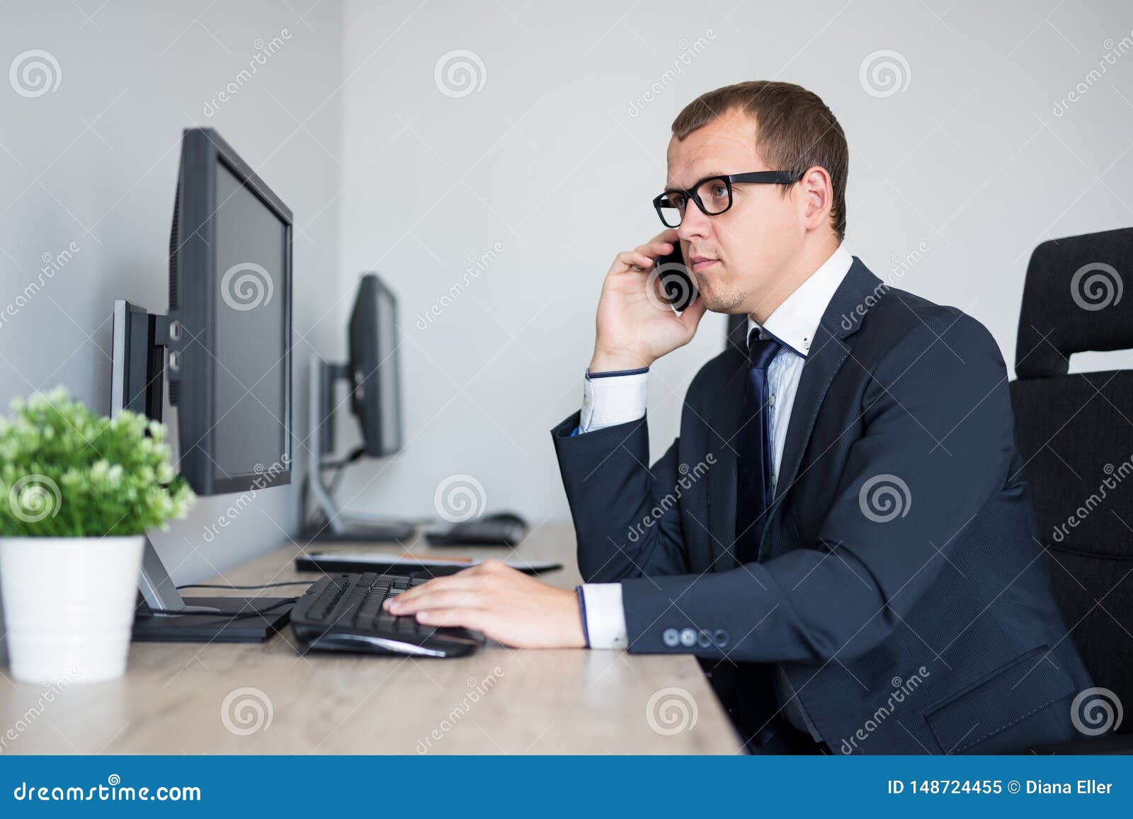 Portrait of Handsome Businessman Using Computer and Talking by Phone in ...