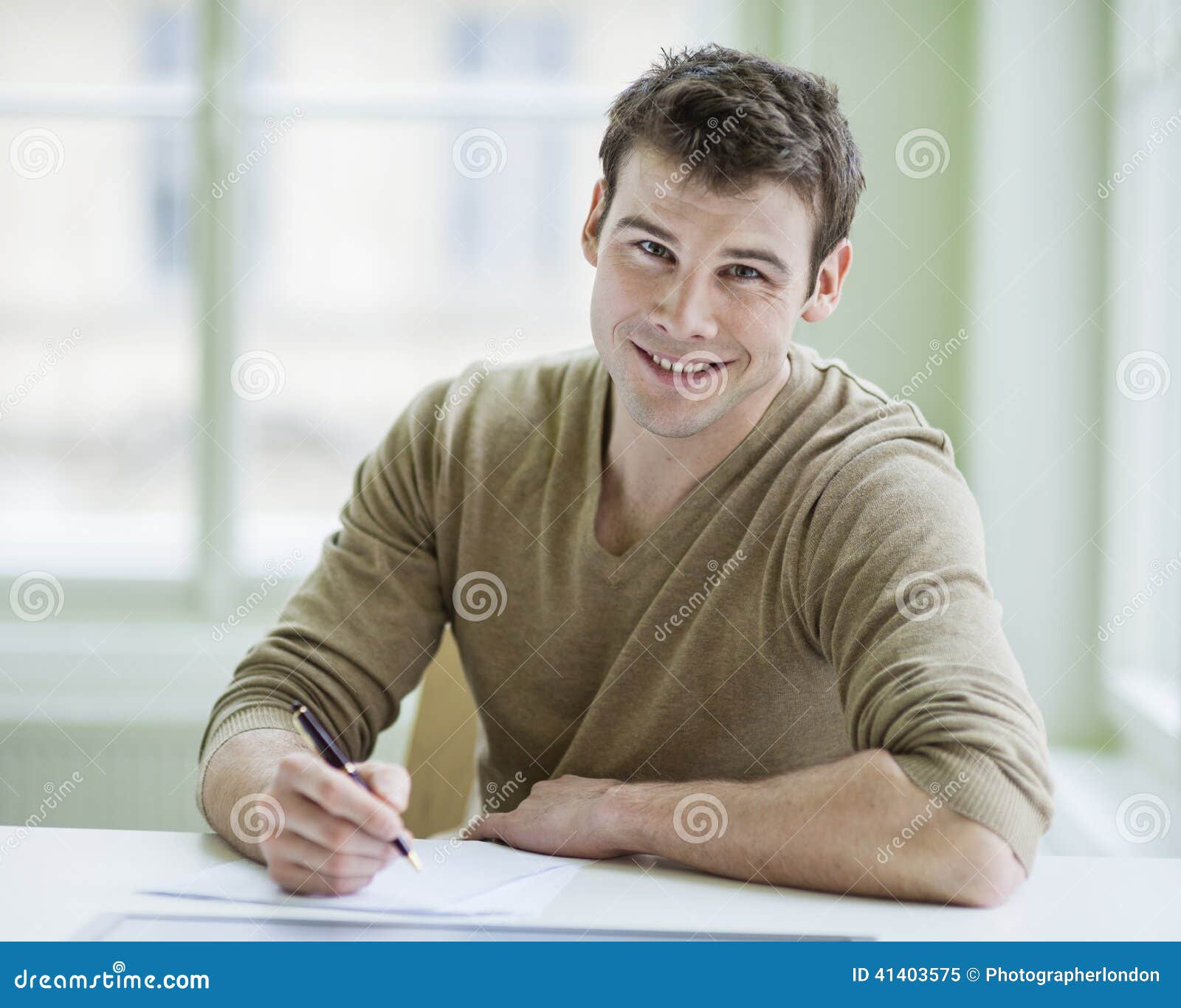 Portrait of Handsome Businessman Writing on Document at Desk in Office ...