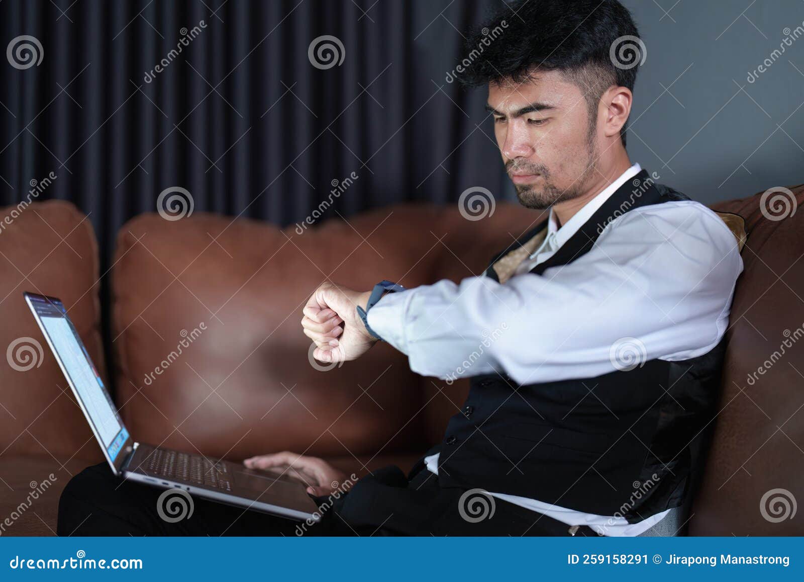 Portrait of a Handsome, Discreet Asian Man Sitting on the Sofa Using a ...