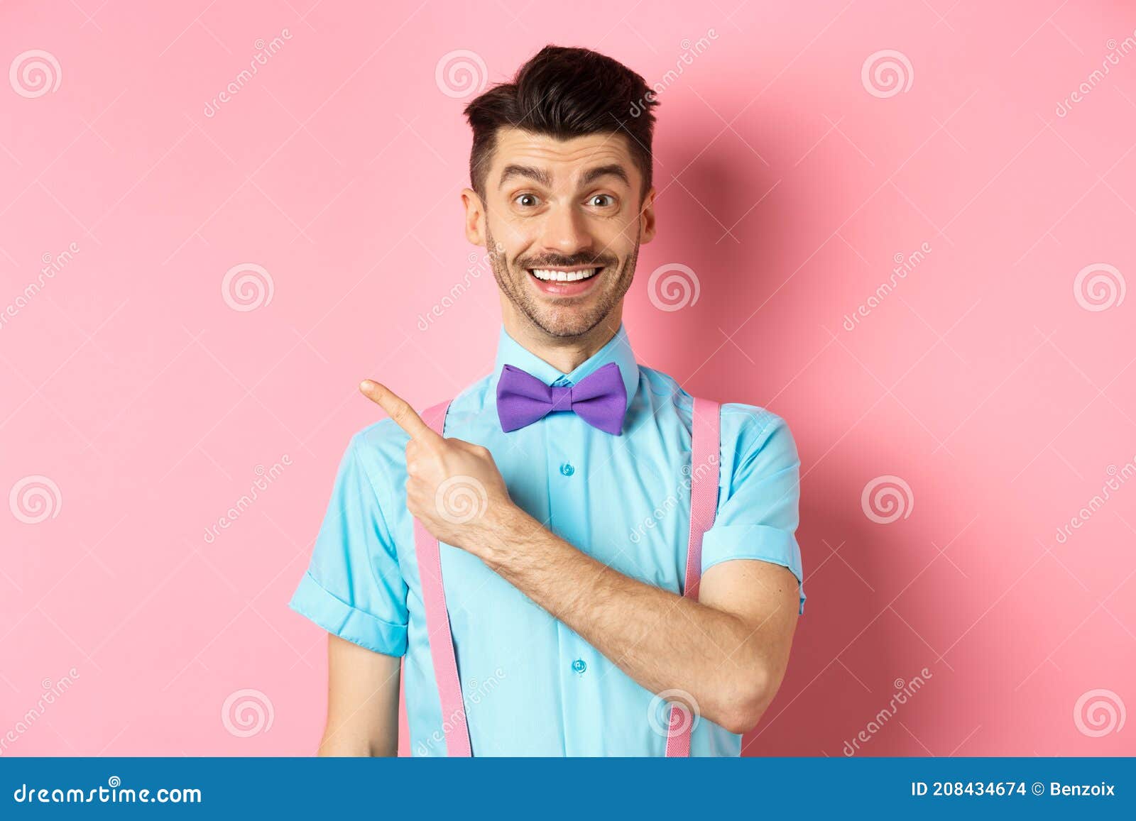 Portrait Of Handsome Happy Man Showing Logo Pointing Left And Smiling