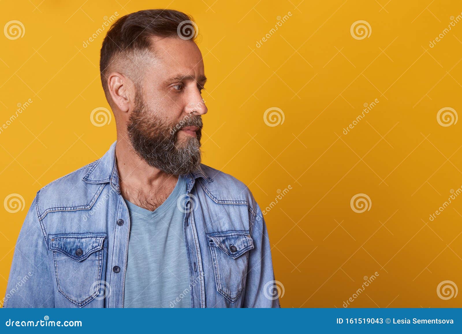 Portrait Of Handsome Man With Beard And Mustache Posing Against Yellow