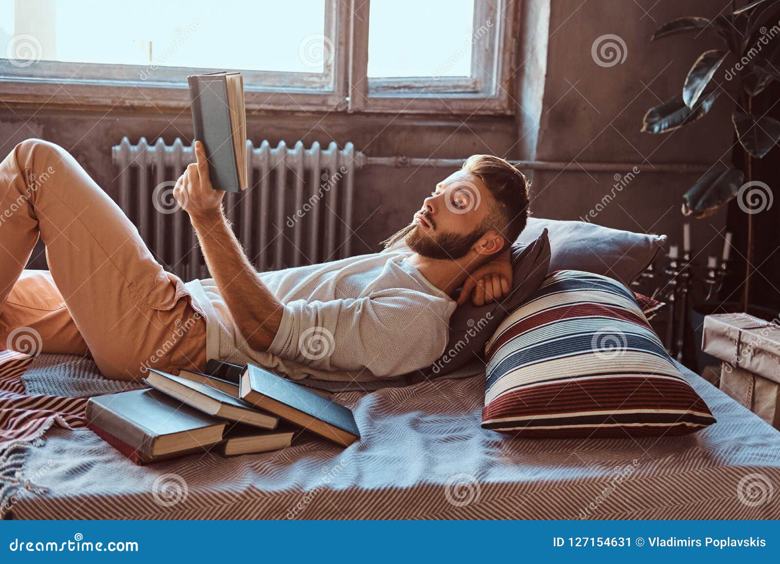 Portrait of a Handsome Student Guy Reading a Book in His Bed. Education ...