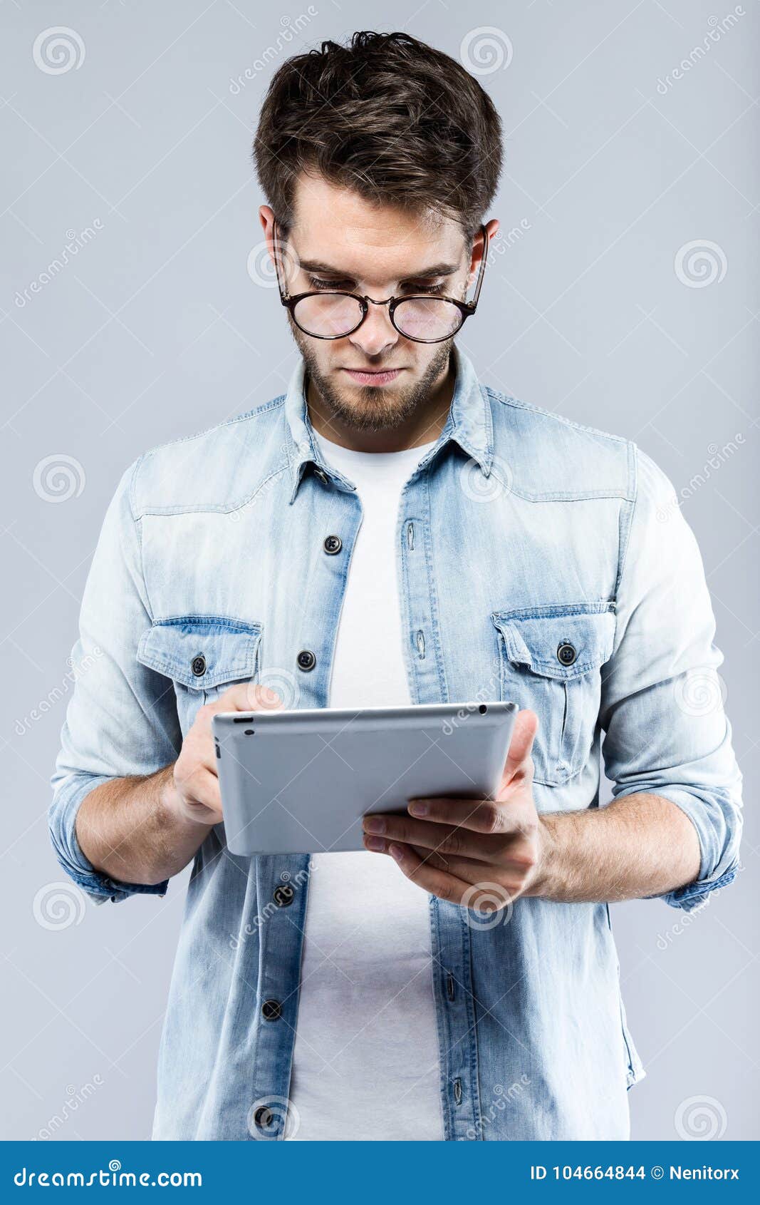 Handsome Young Man Using His Digital Tablet Over Gray Background Stock