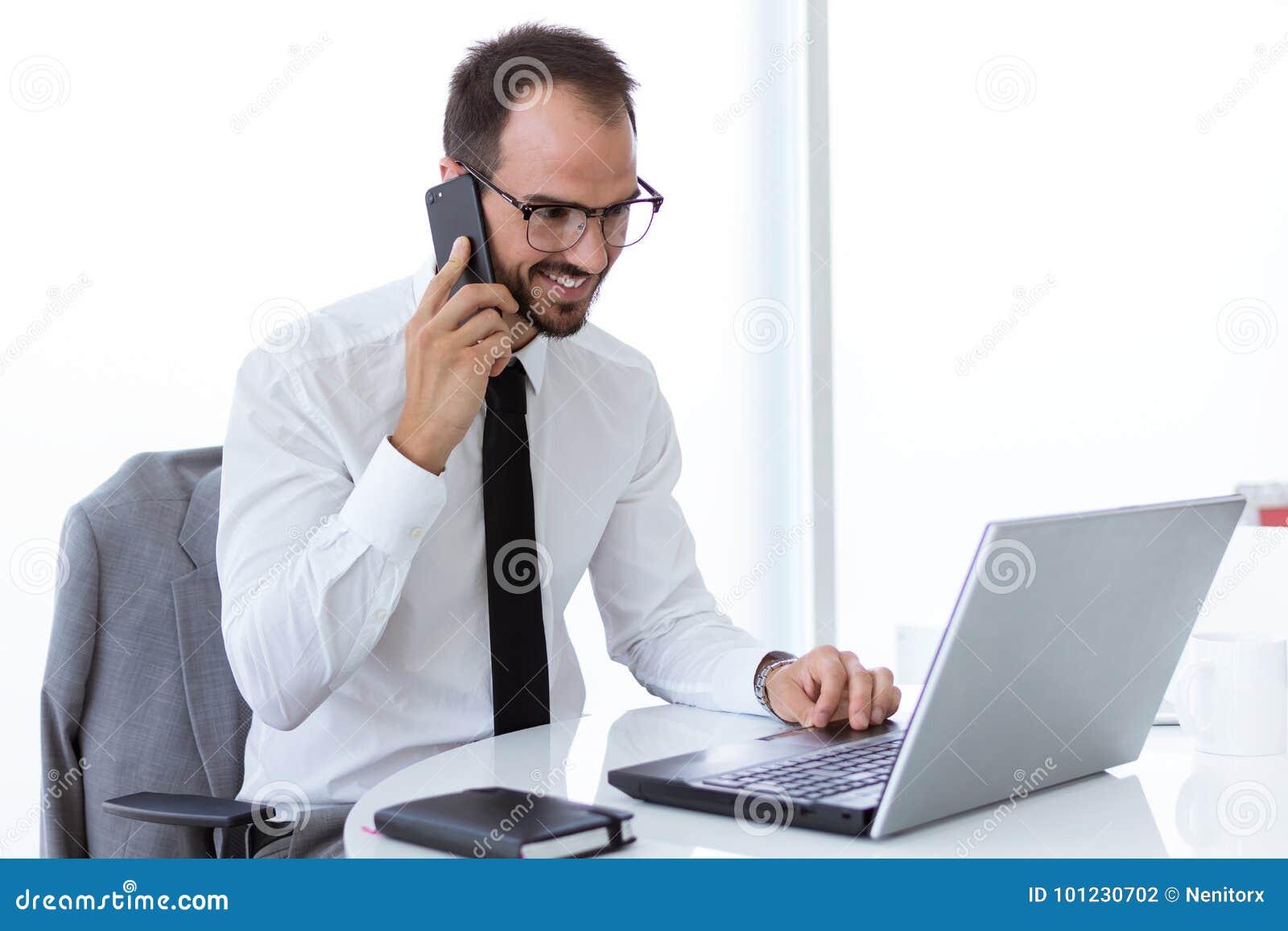 Handsome Young Man Working with Laptop and Mobile Phone in the Office ... Handsome Young Man Working with Laptop and Mobile Phone in the Office ...
