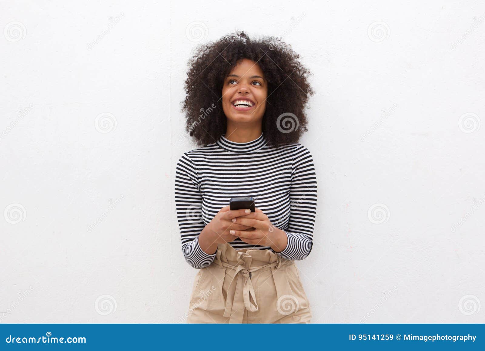 Happy African Couple Laughing Using Smartphones Isolated On Pink