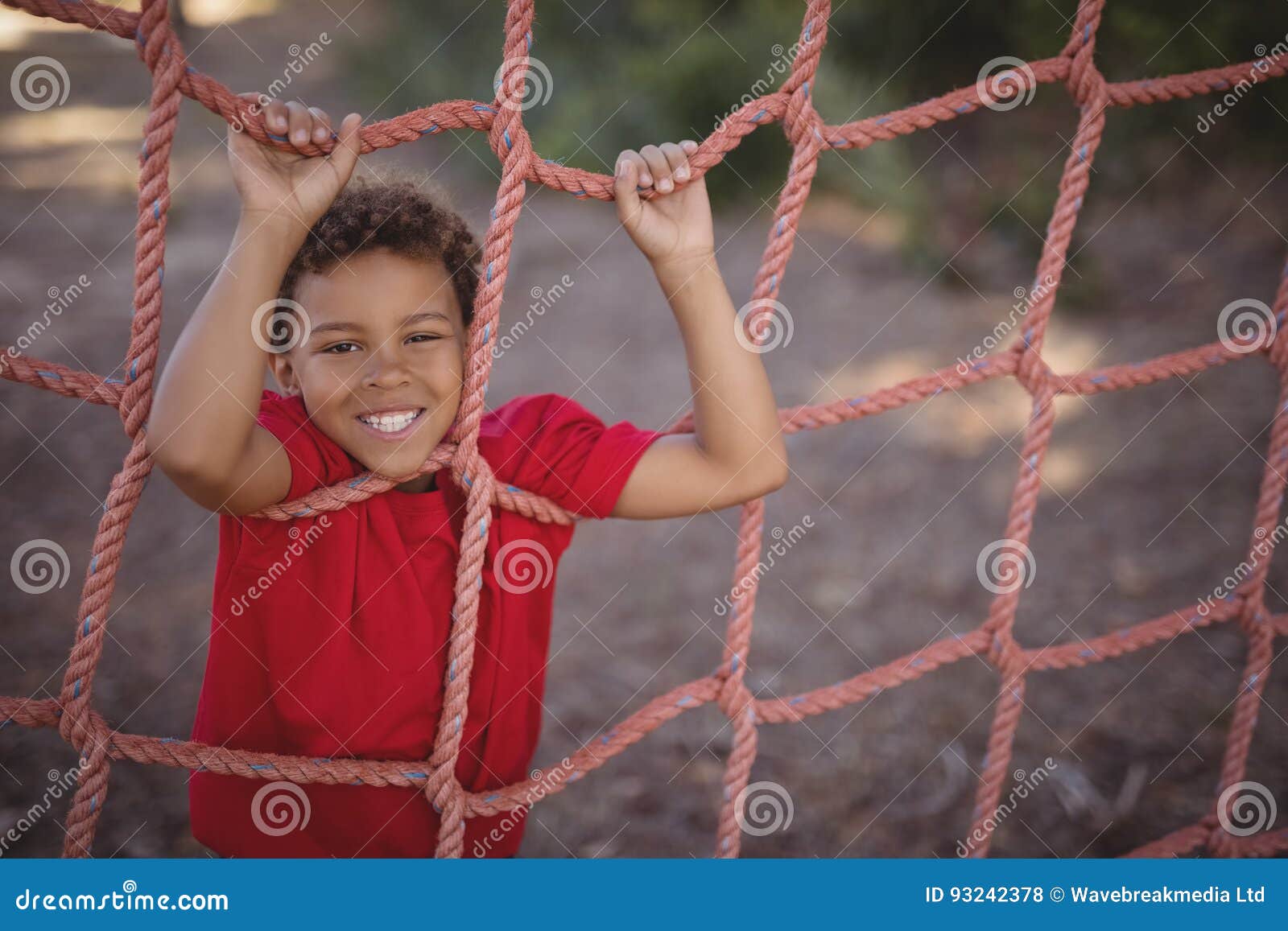 Portrait of Happy Boy Leaning on Net during Obstacle Course Stock Photo ...