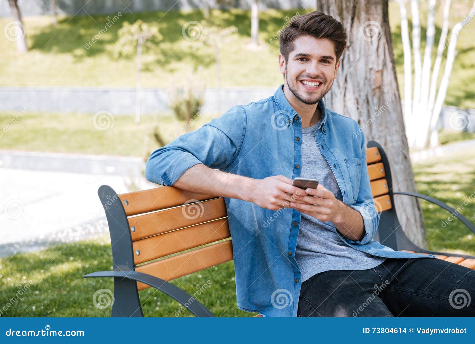 Portrait of a Happy Man Sitting on the Bench Outdoors Stock Photo ...