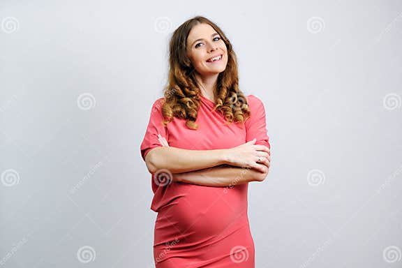 Portrait Of Happy Pregnant Young Woman Crossing Her Arms On Chest