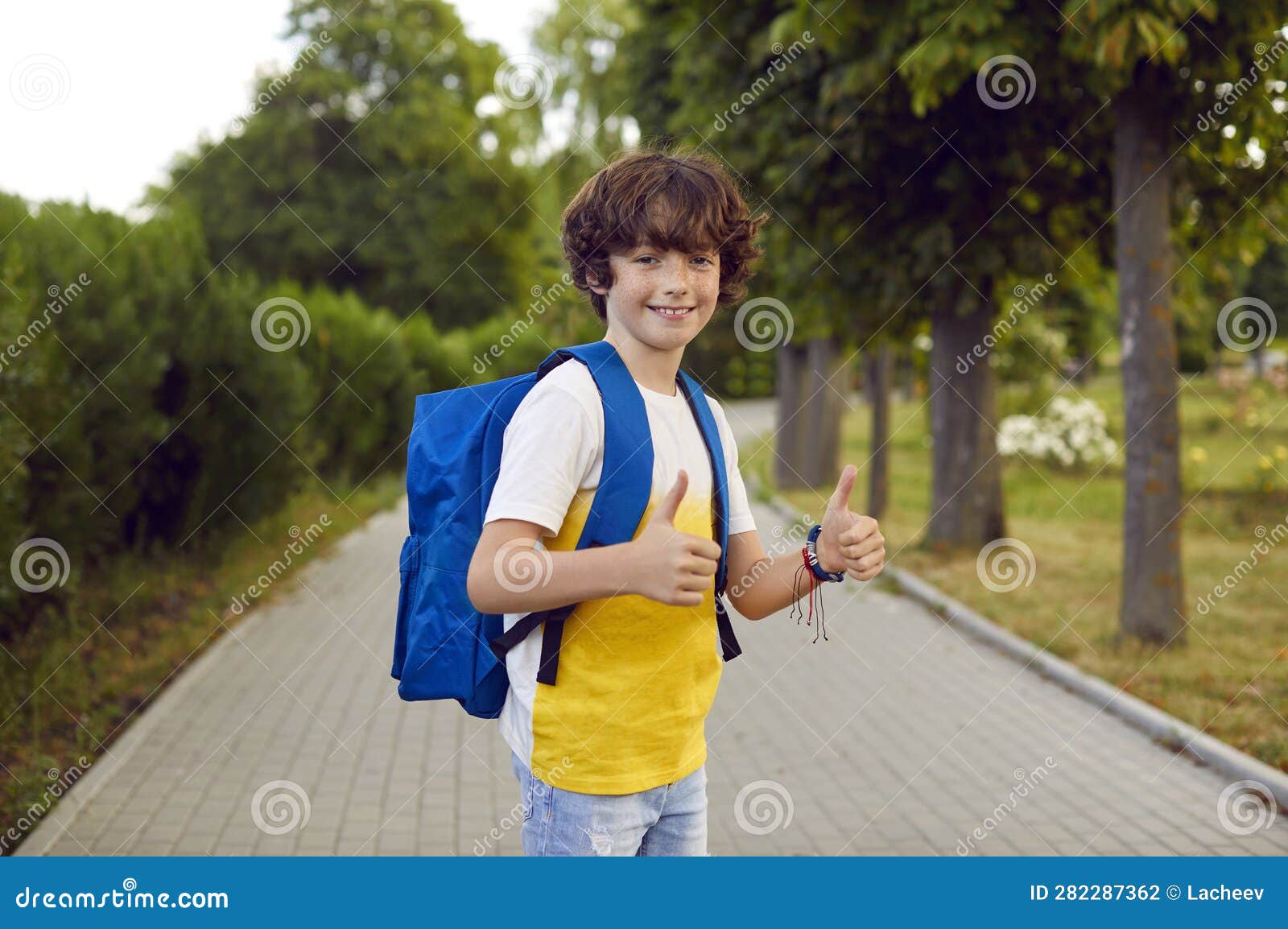 Portrait of Happy School Student with Backpack Standing in Park and ...