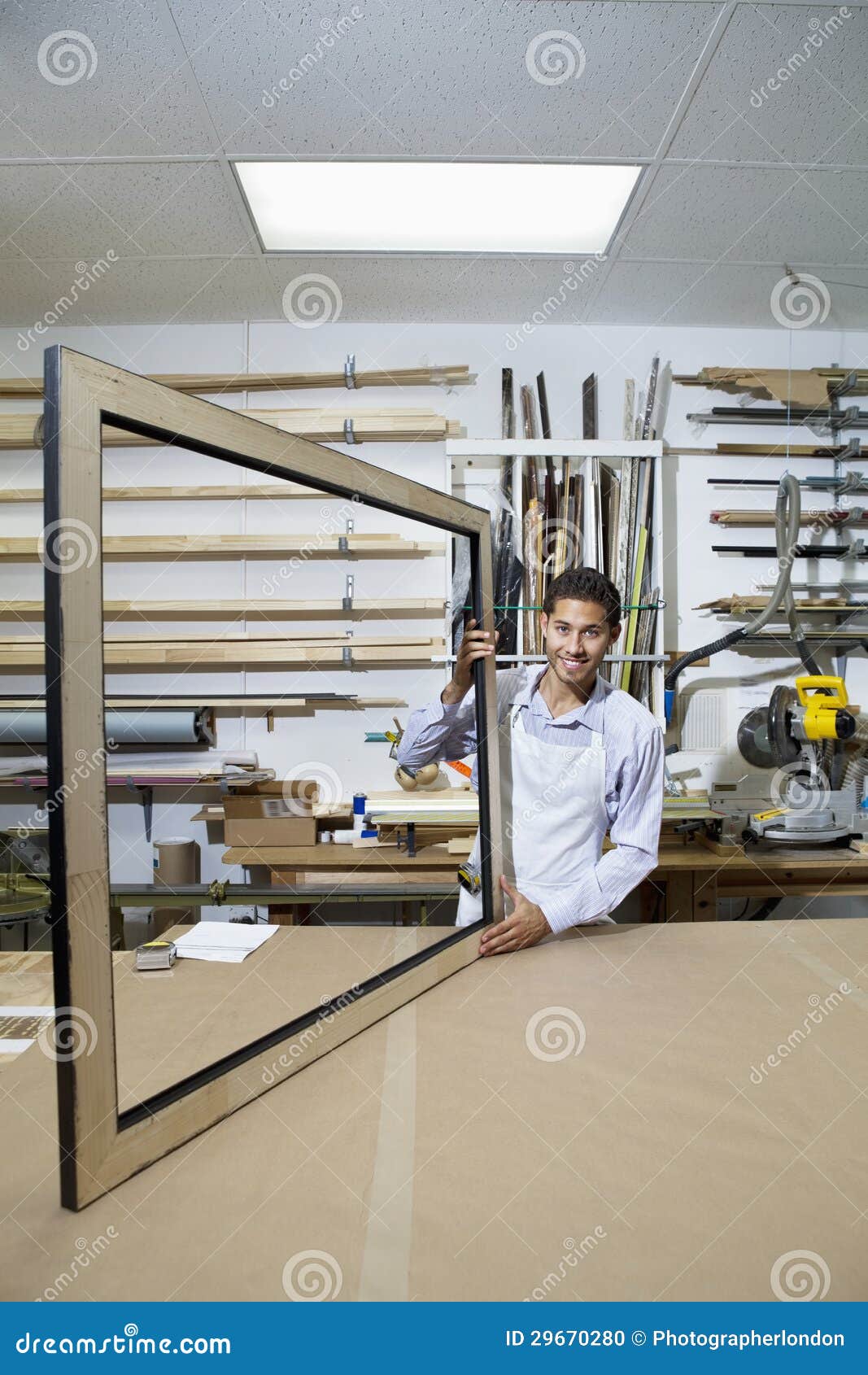Portrait of a Happy Young Man Working on Big Picture Frame in Workshop ...