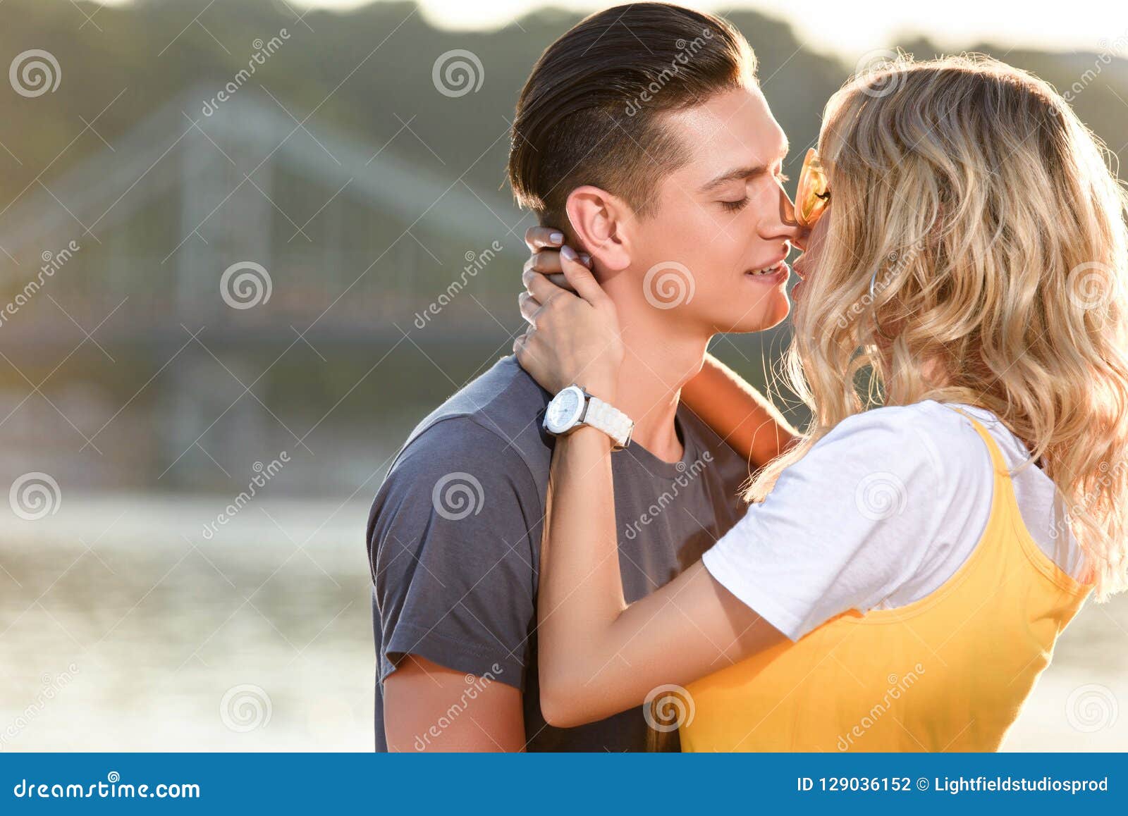 Portrait Of Heterosexual Couple Going To Kiss On River Beach Stock