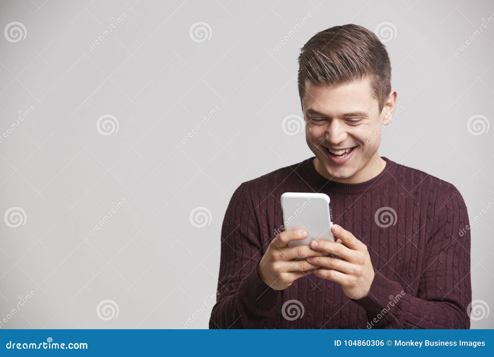 Portrait of a Laughing Young White Man Using a Smartphone Stock Photo ...