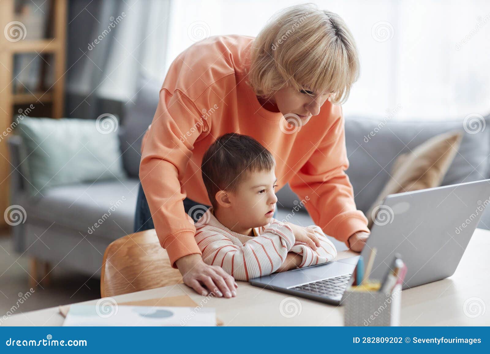 Little Boy with Down Syndrome Using Computer with Mom Assisting Stock ...